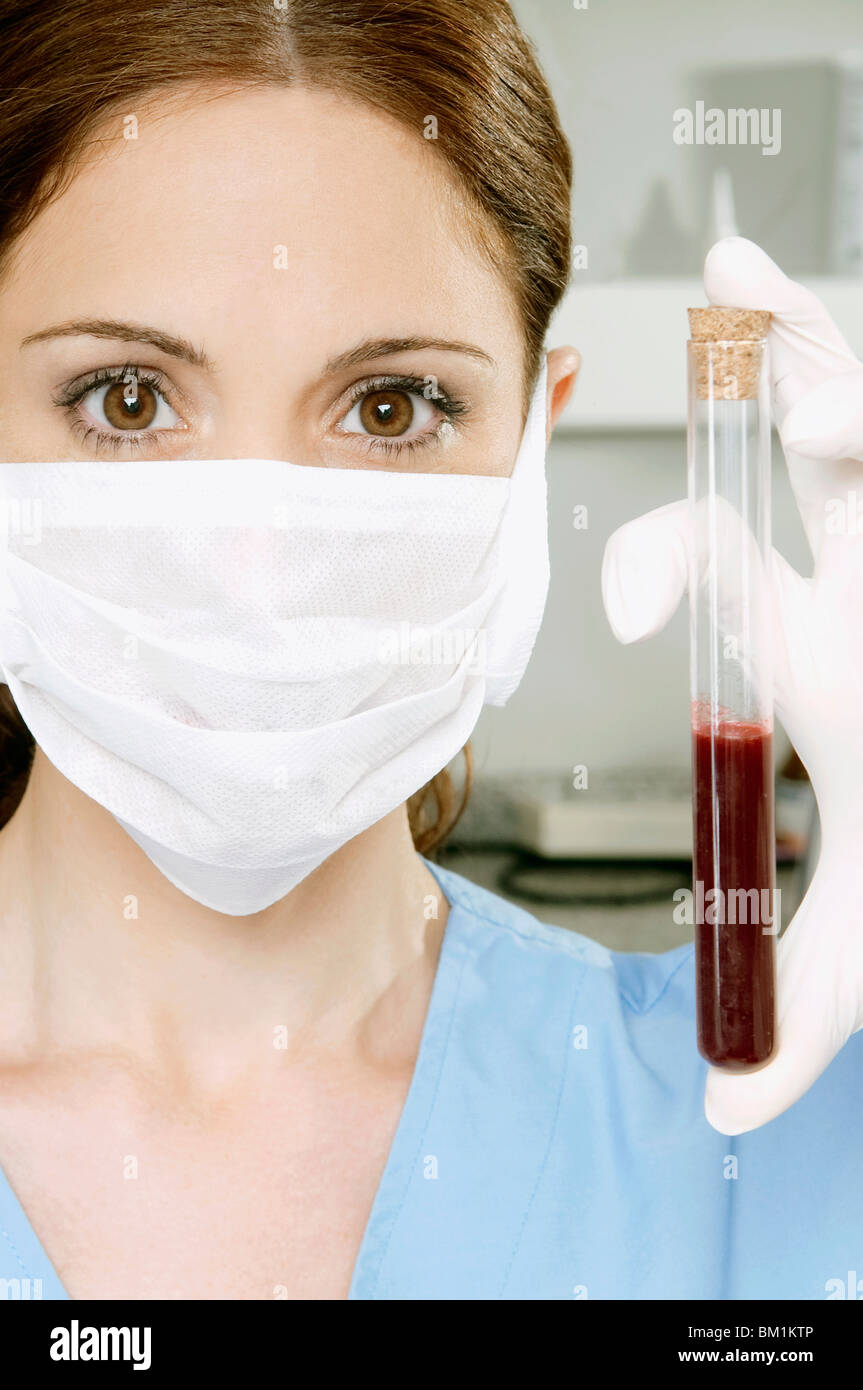 Female lab technician holding blood sample in a test tube Stock Photo ...