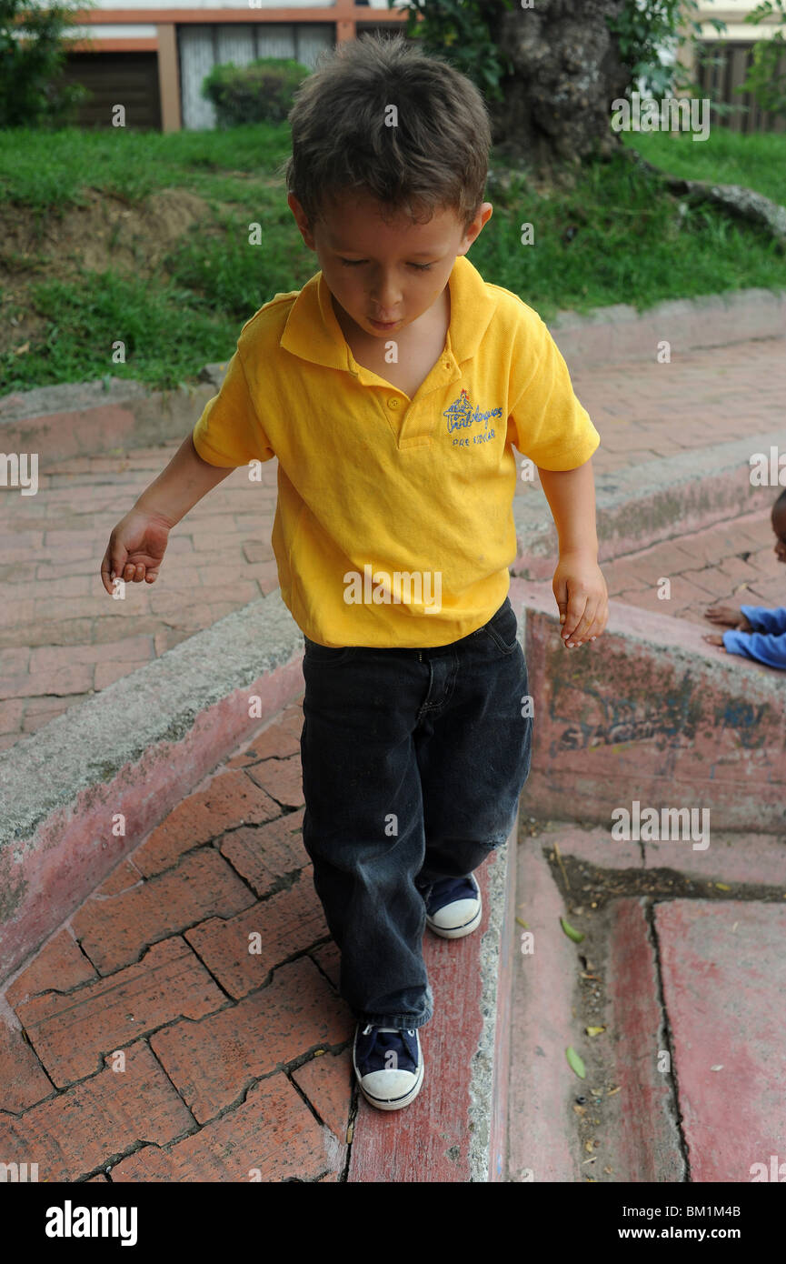boy 4 years walking along wall in park in Medellin Stock Photo - Alamy