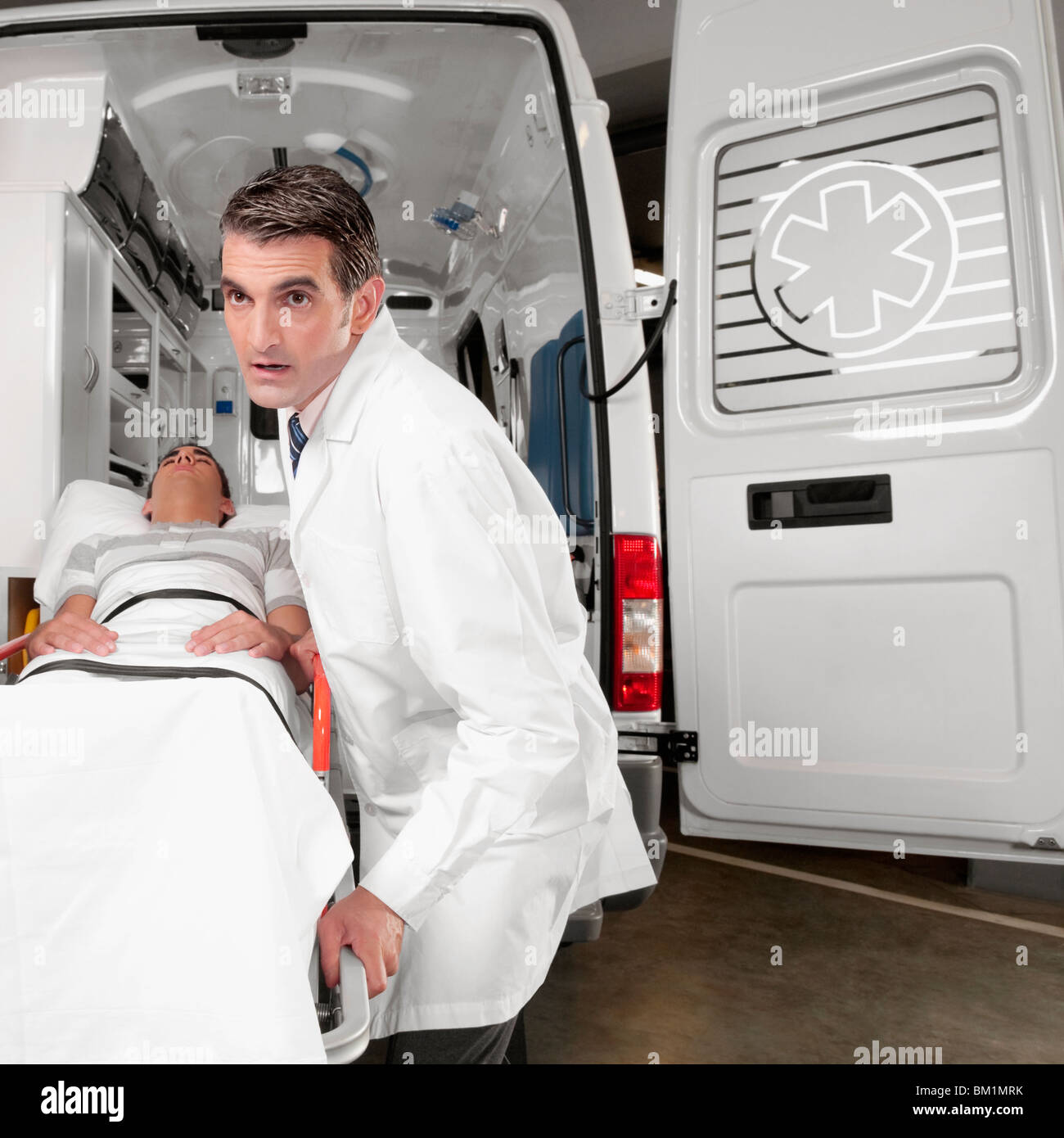 Doctor pushing a patient on a gurney from an ambulance Stock Photo - Alamy