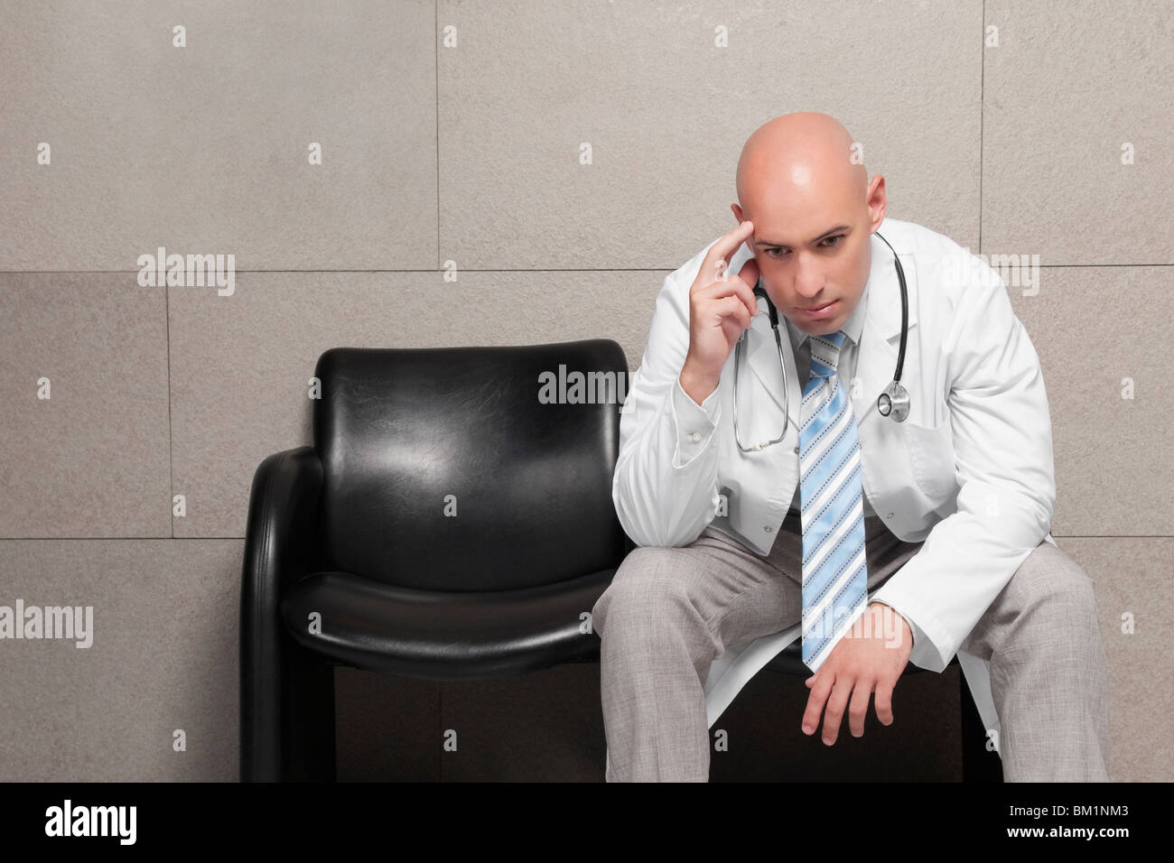 Doctor sitting on a chair and looking stressed Stock Photo - Alamy