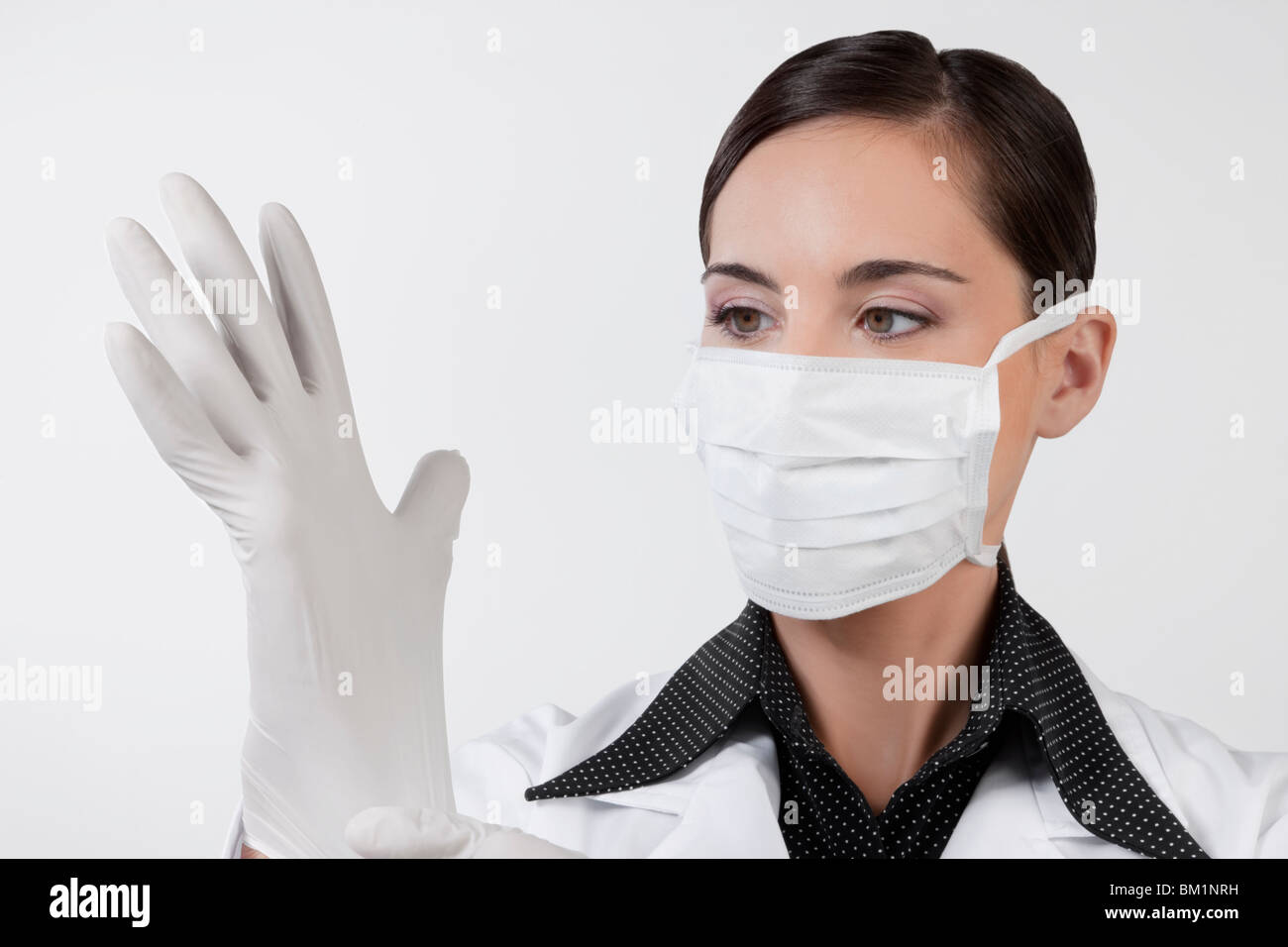 Female doctor putting on surgical gloves Stock Photo - Alamy