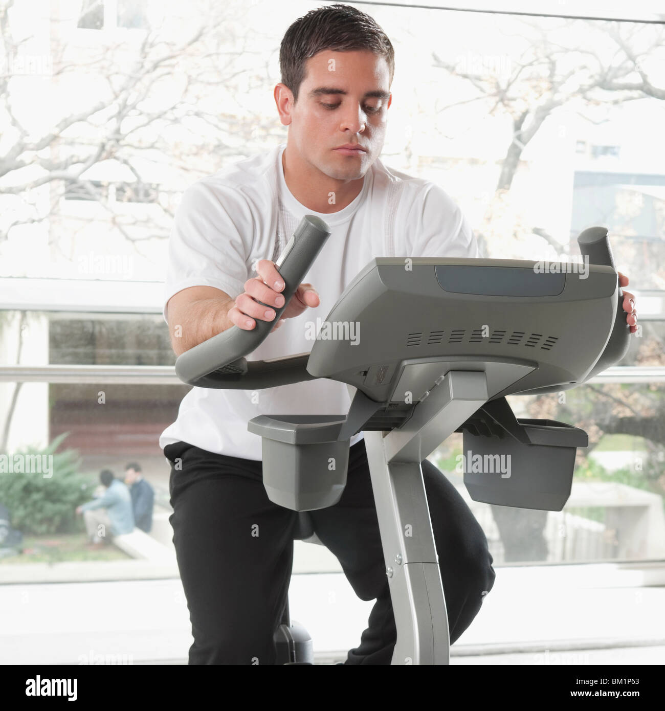 Man working out on an exercise bike in a gym Stock Photo - Alamy