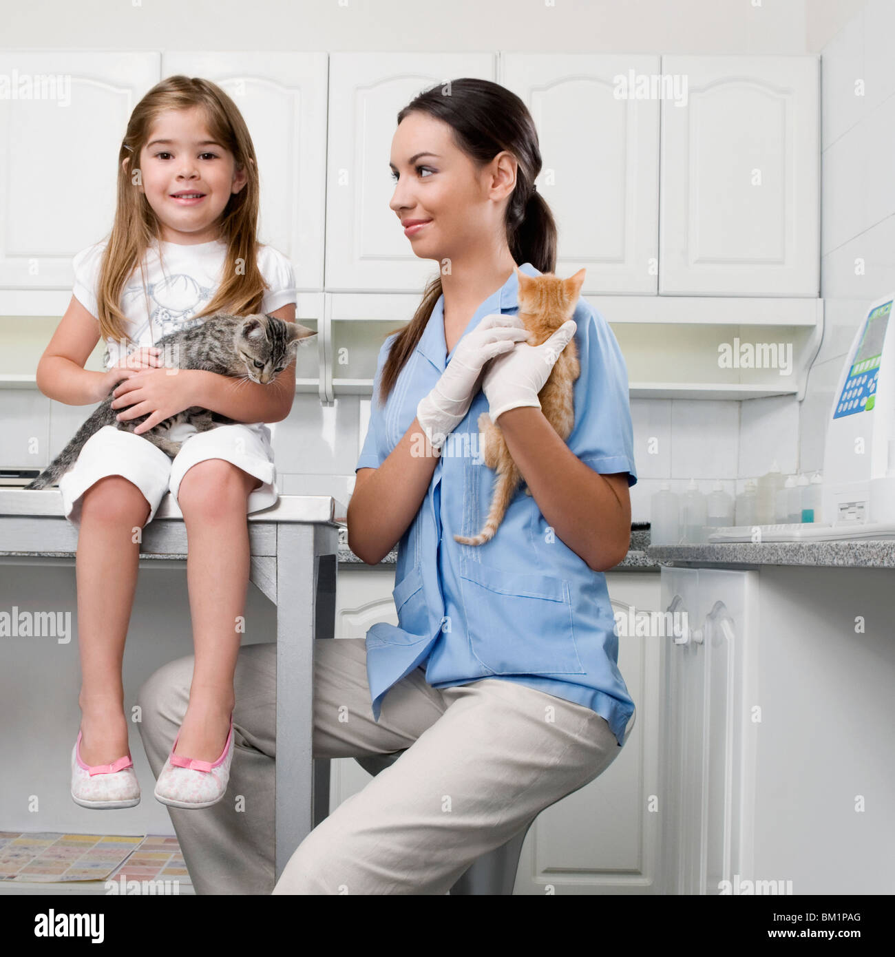Female vet with a girl carrying cats Stock Photo - Alamy