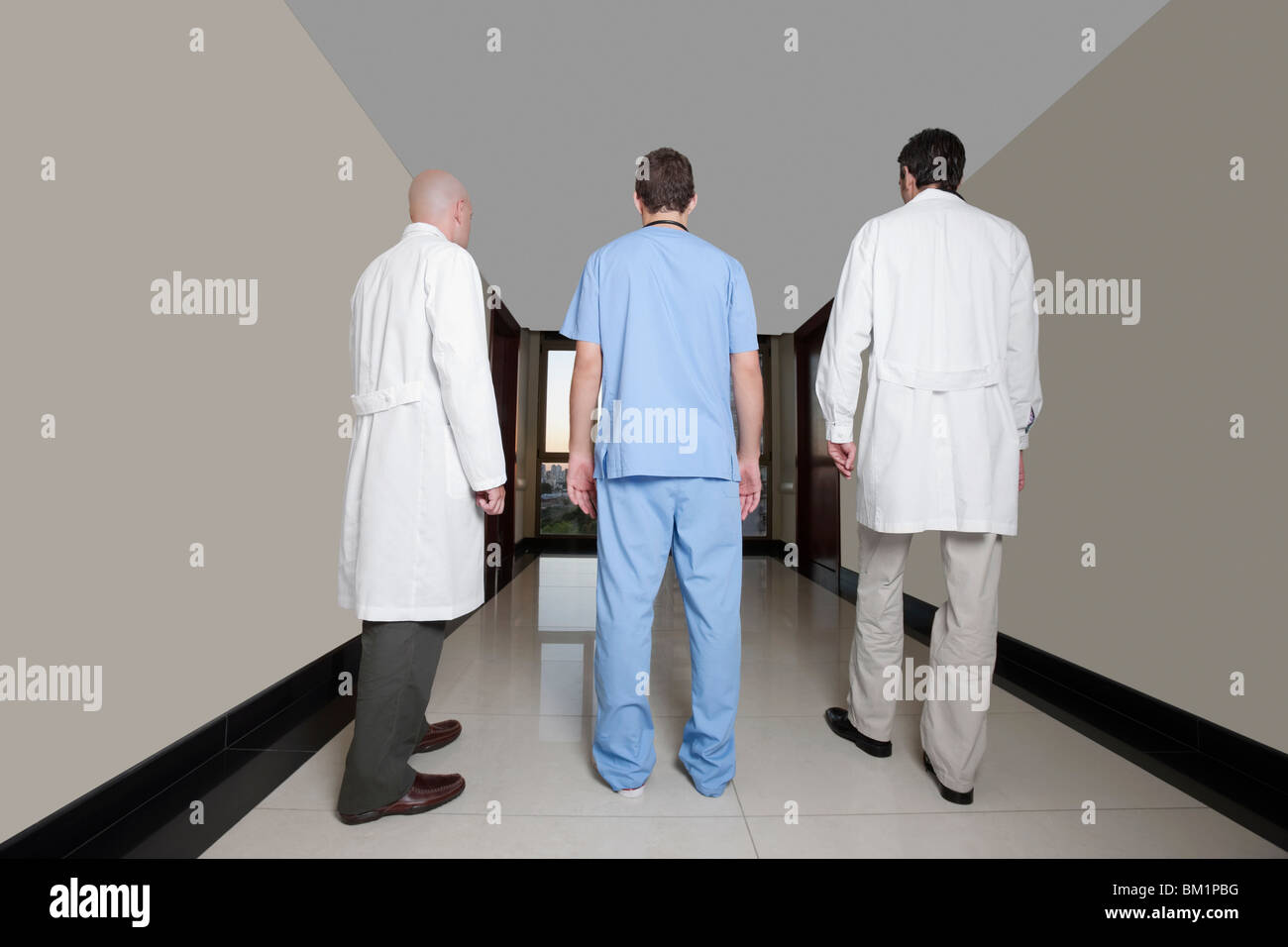 Two male doctors with a surgeon walking in a hospital corridor Stock ...