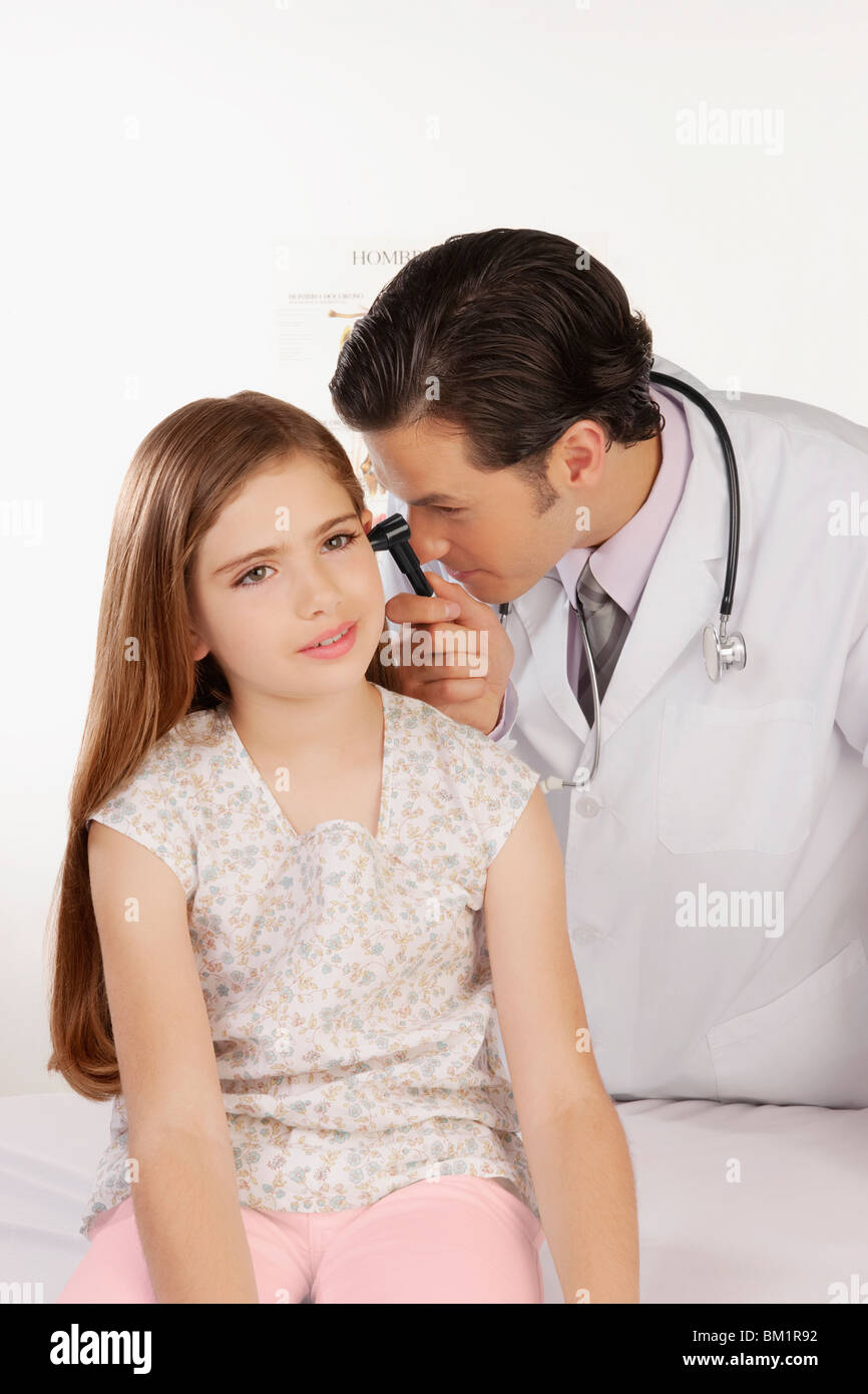 Doctor examining a girl's ear with an otoscope Stock Photo - Alamy