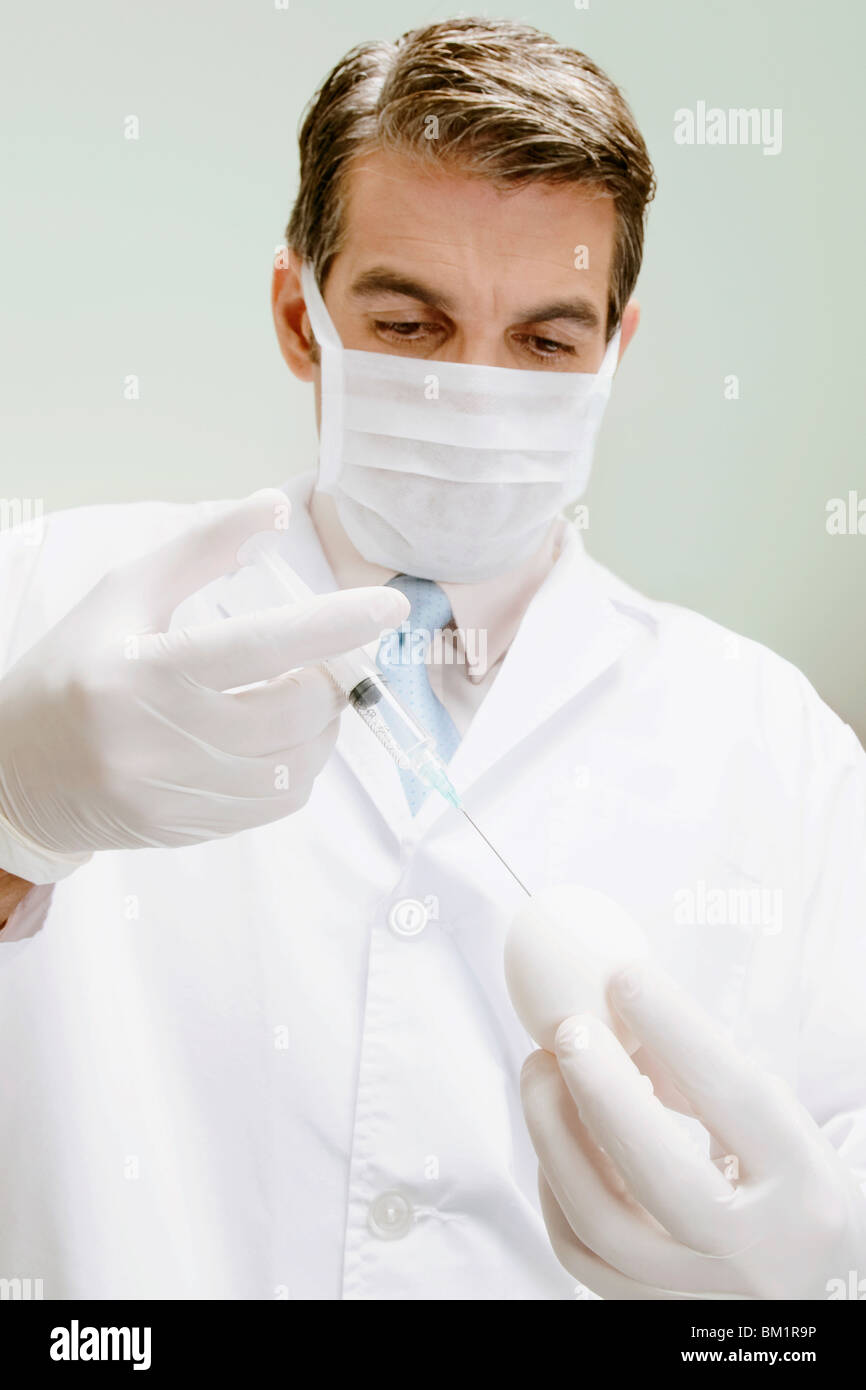 Lab technician injecting into an egg Stock Photo - Alamy
