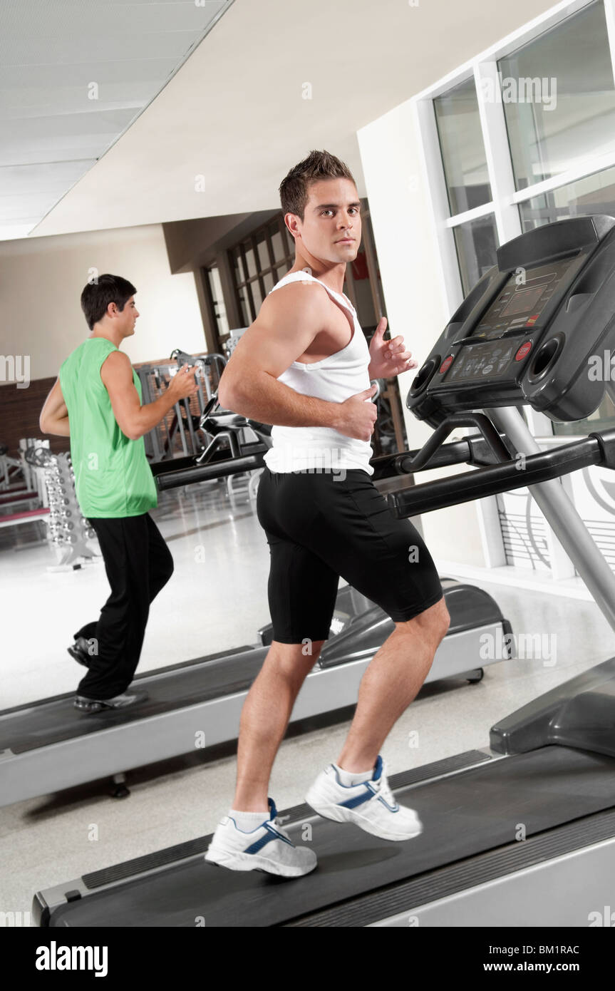 Two men running on treadmills Stock Photo - Alamy