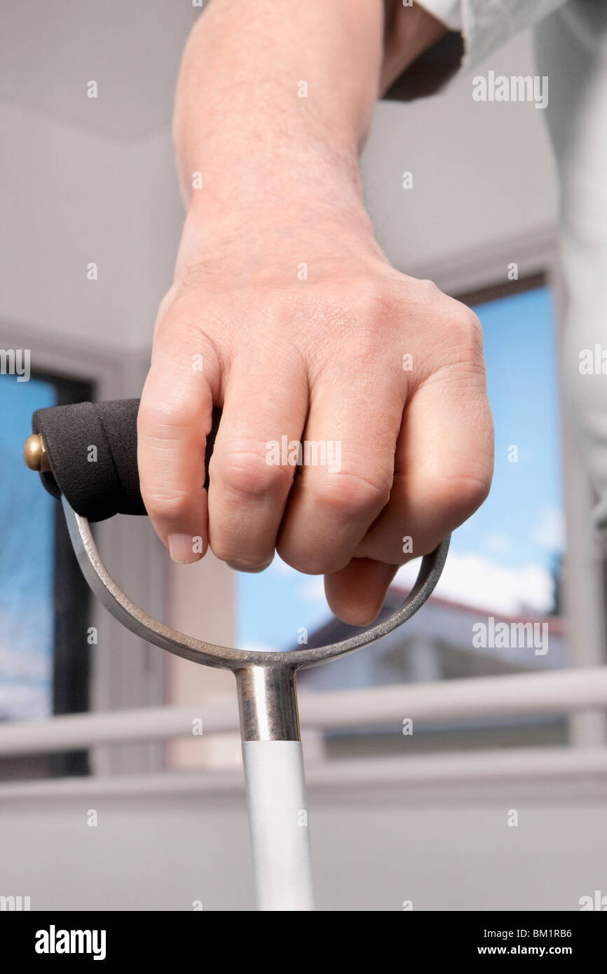 Human hand holding a crutch Stock Photo - Alamy