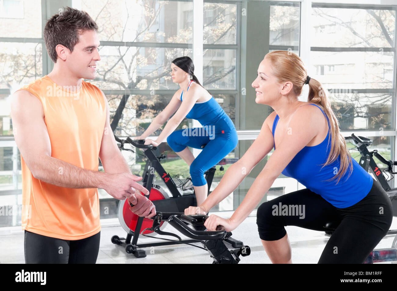 Three people working out in a gym Stock Photo - Alamy