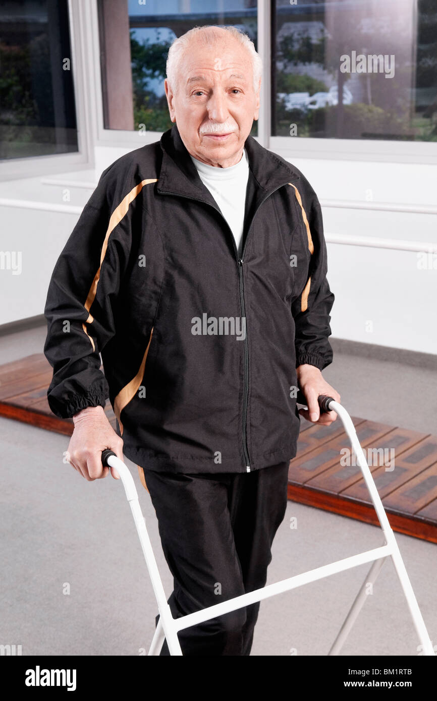 Portrait of a disabled man walking with a walker Stock Photo - Alamy