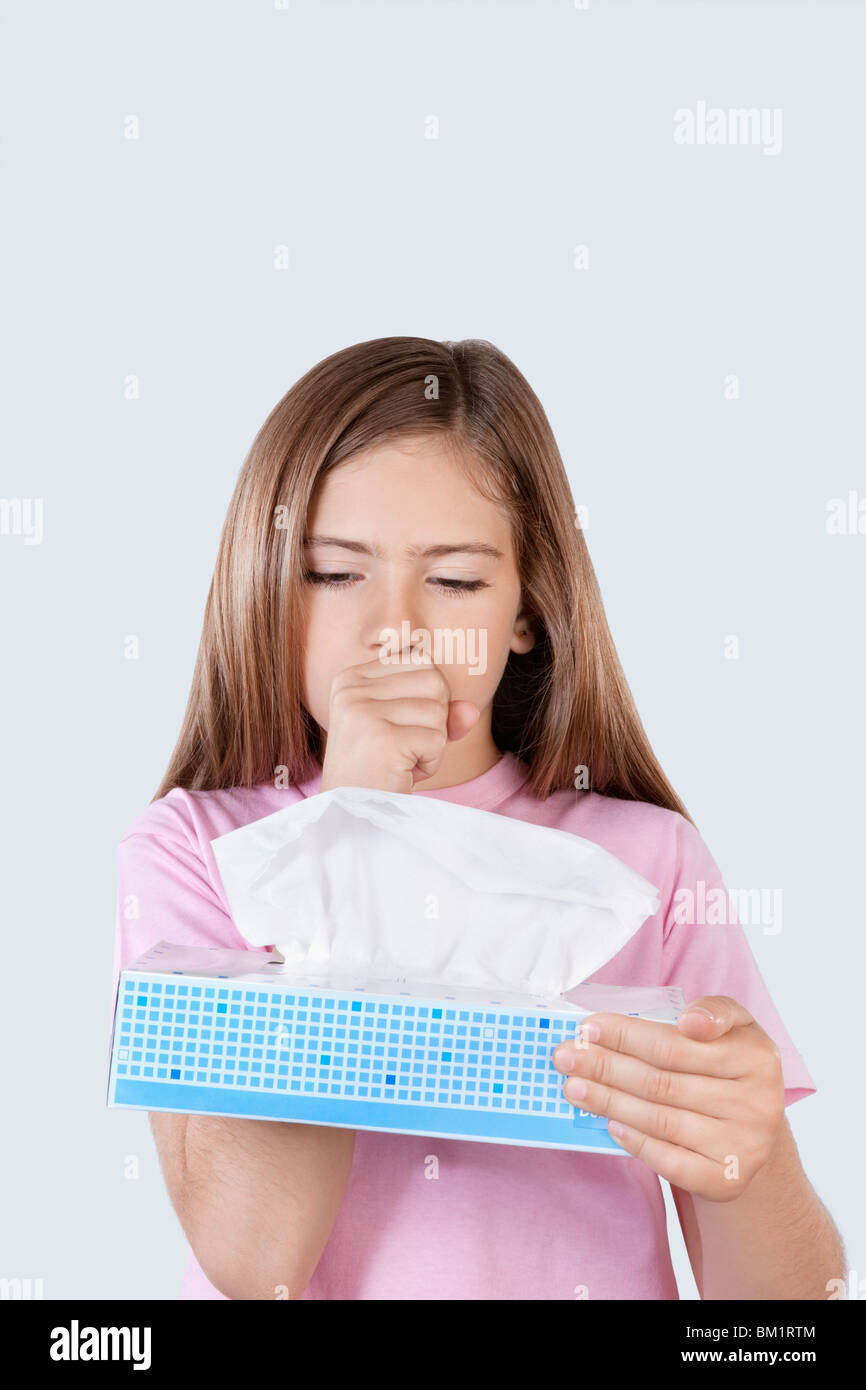 Girl holding a flu mask box and coughing Stock Photo - Alamy