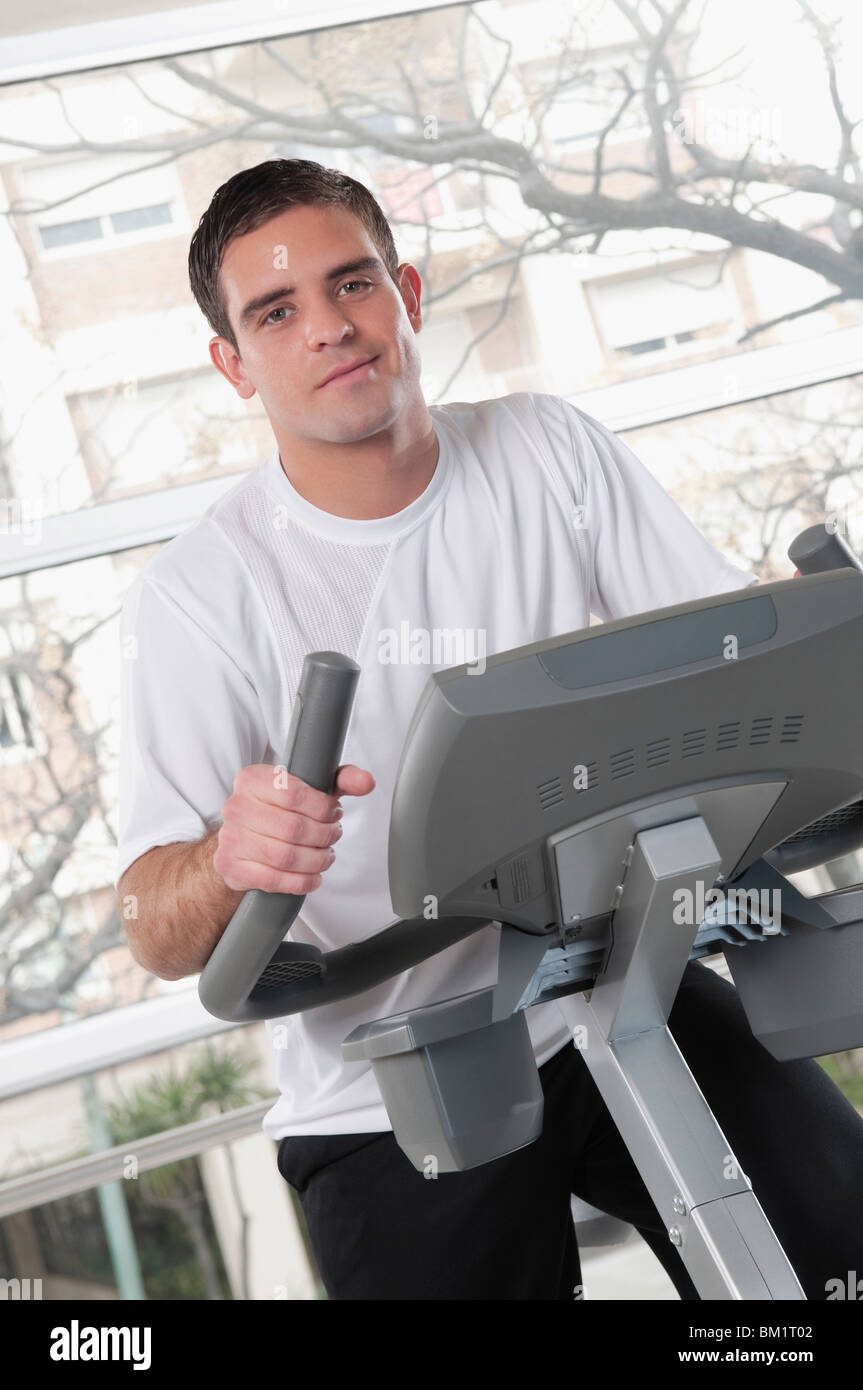 Man working out on an exercise bike in a gym Stock Photo - Alamy