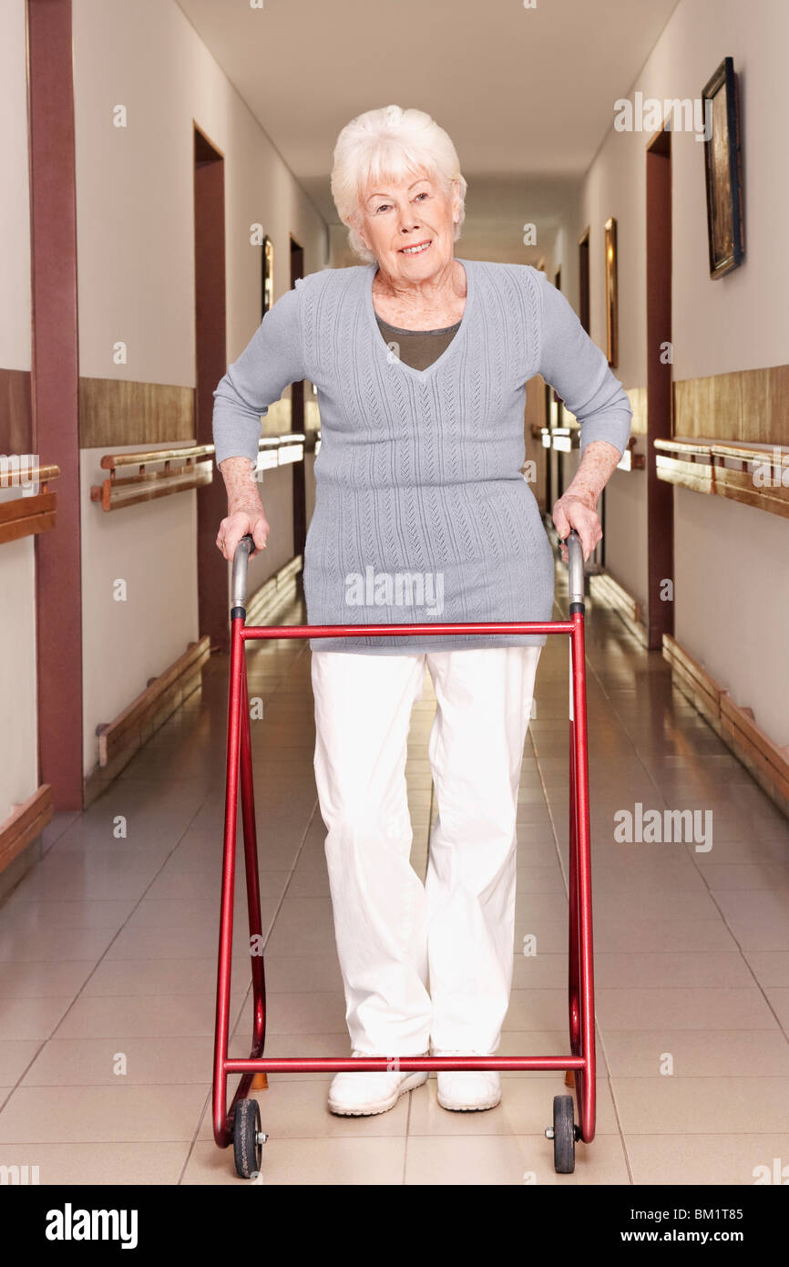 Woman walking with the help of a walker Stock Photo - Alamy