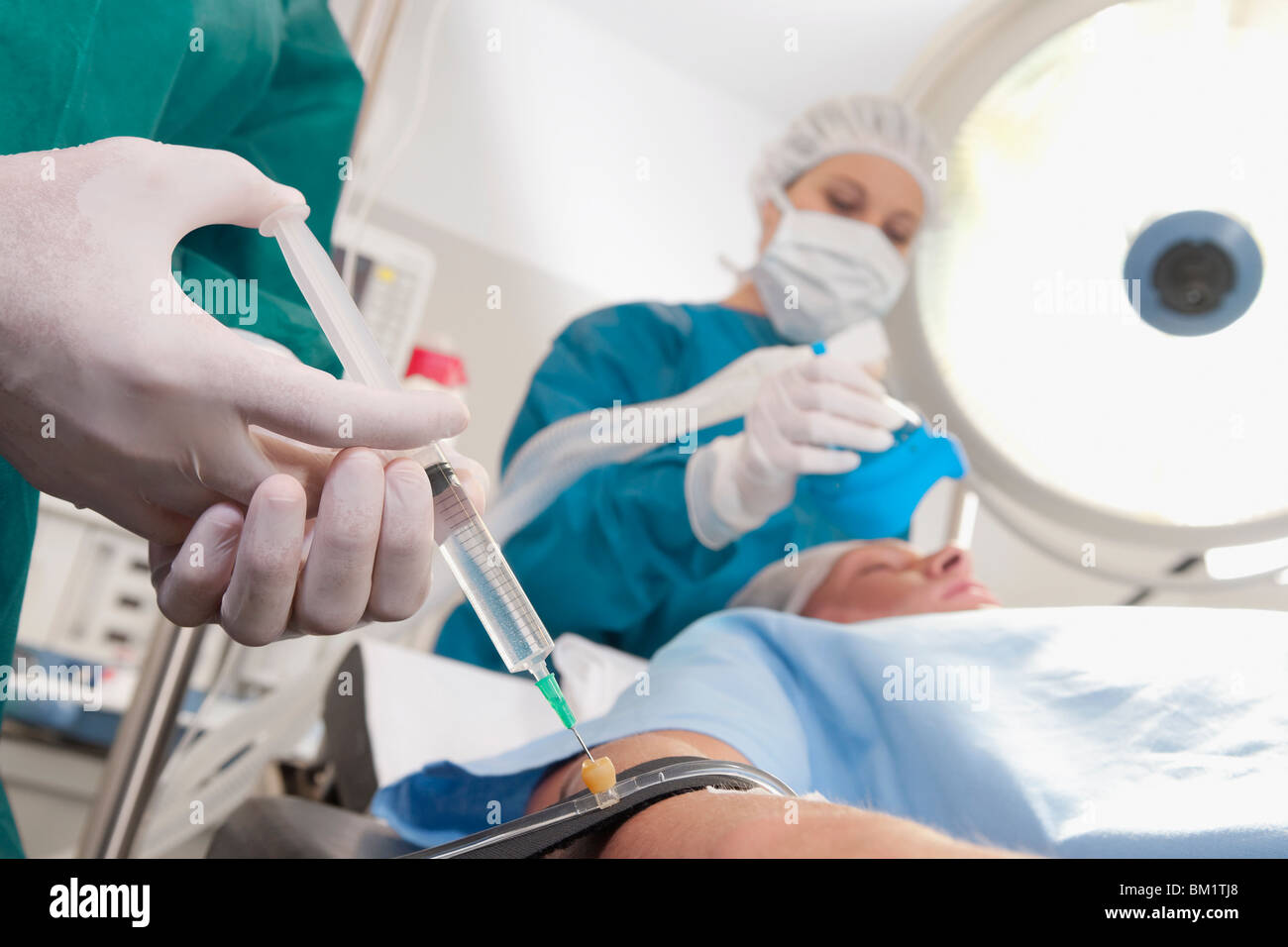 Doctor injecting patient's arm in an operating room Stock Photo - Alamy