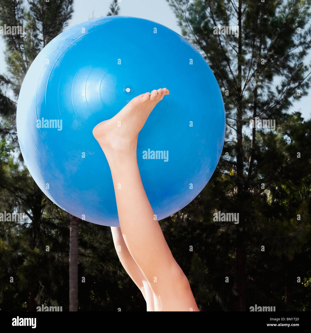 Person's legs holding a fitness ball Stock Photo - Alamy