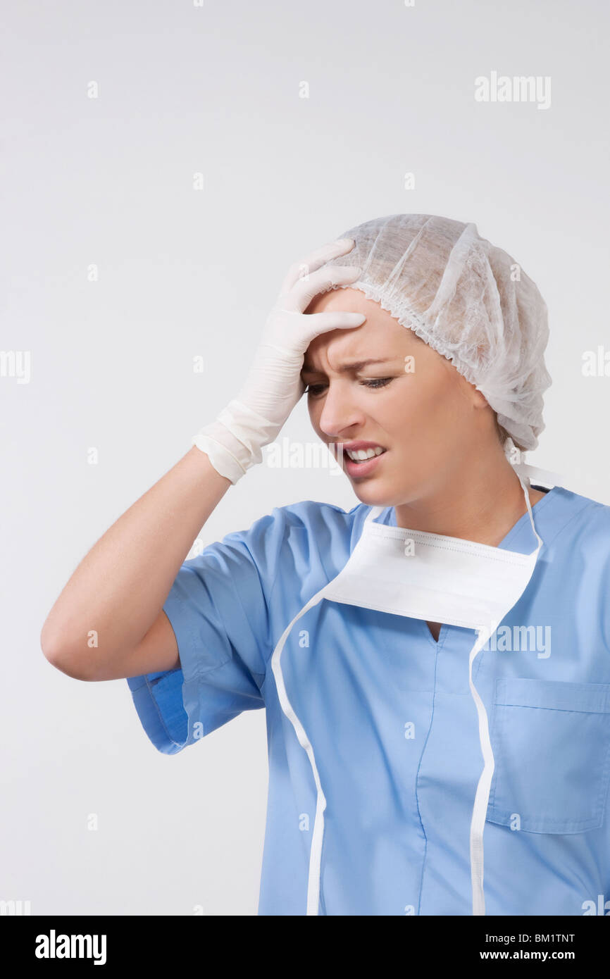 Female surgeon suffering from a headache Stock Photo - Alamy