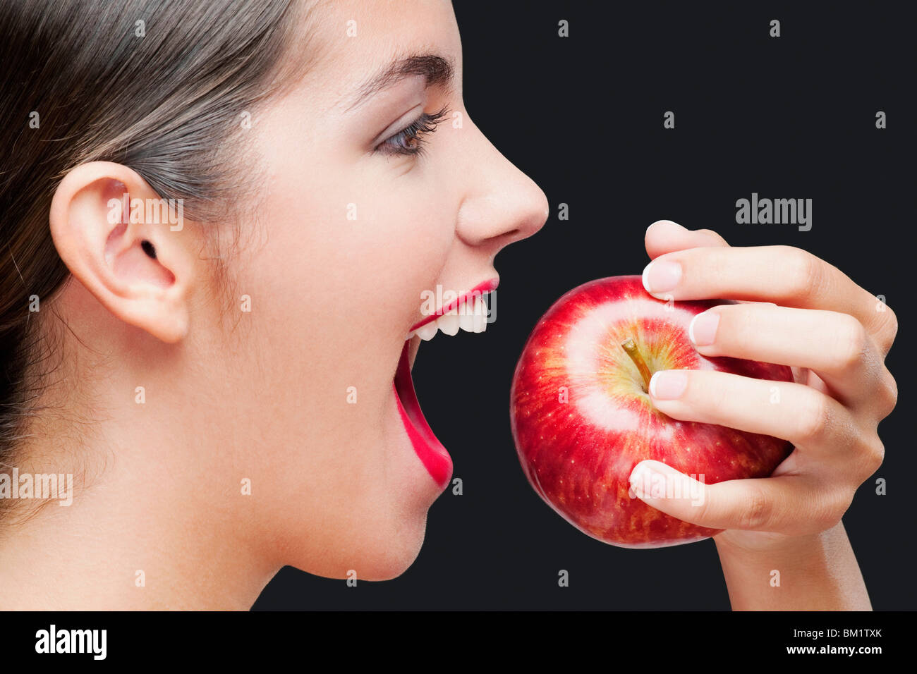 Close-up of a woman eating a red apple Stock Photo - Alamy