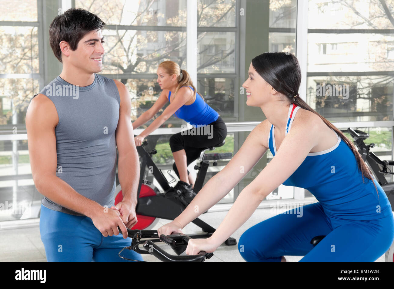 Three people working out in a gym Stock Photo - Alamy