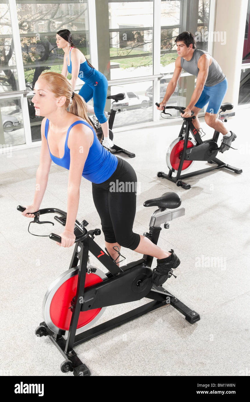 Three people working out in a gym Stock Photo - Alamy