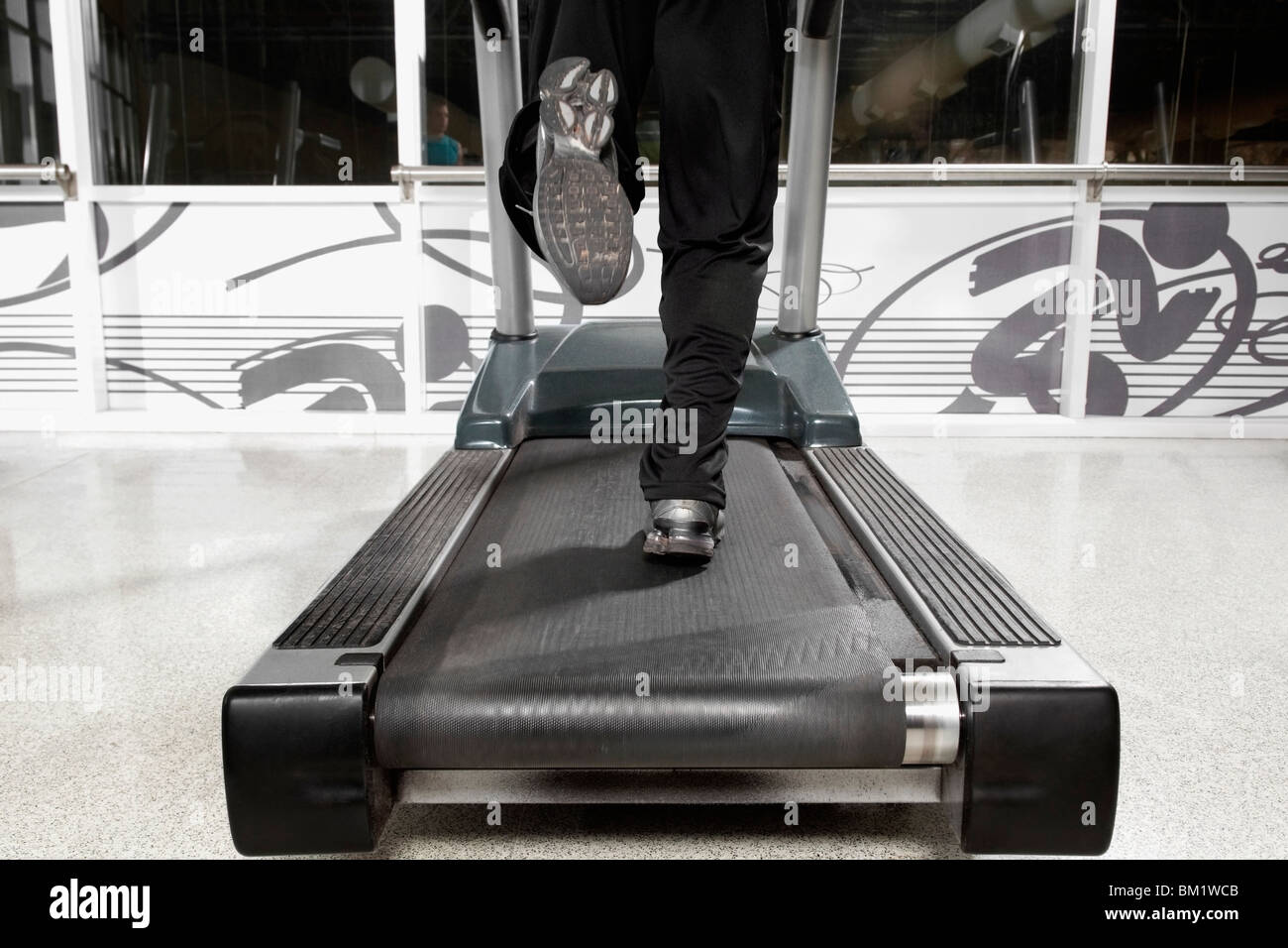 Low section view of a man running on a treadmill Stock Photo - Alamy