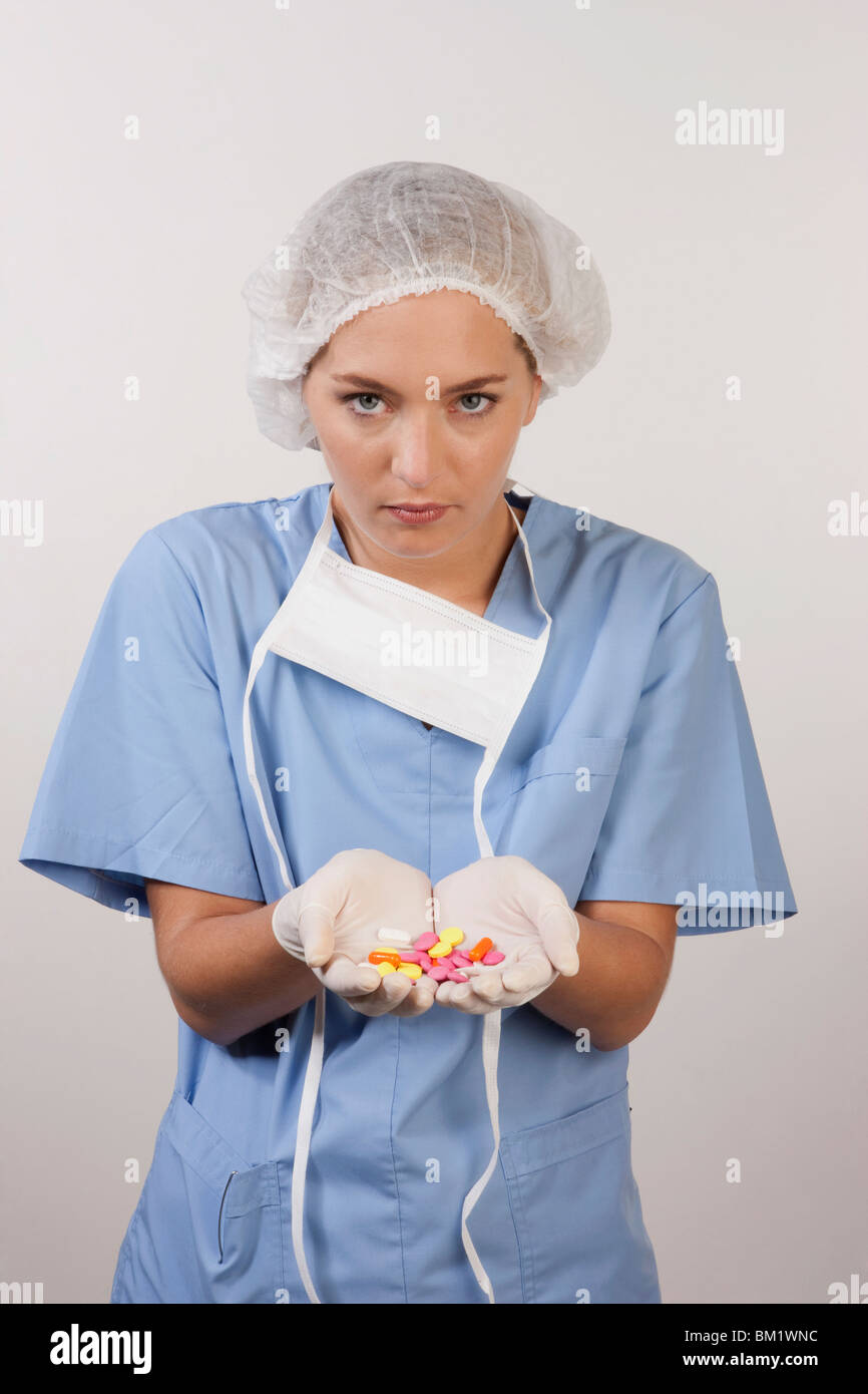 Female nurse holding pills Stock Photo - Alamy