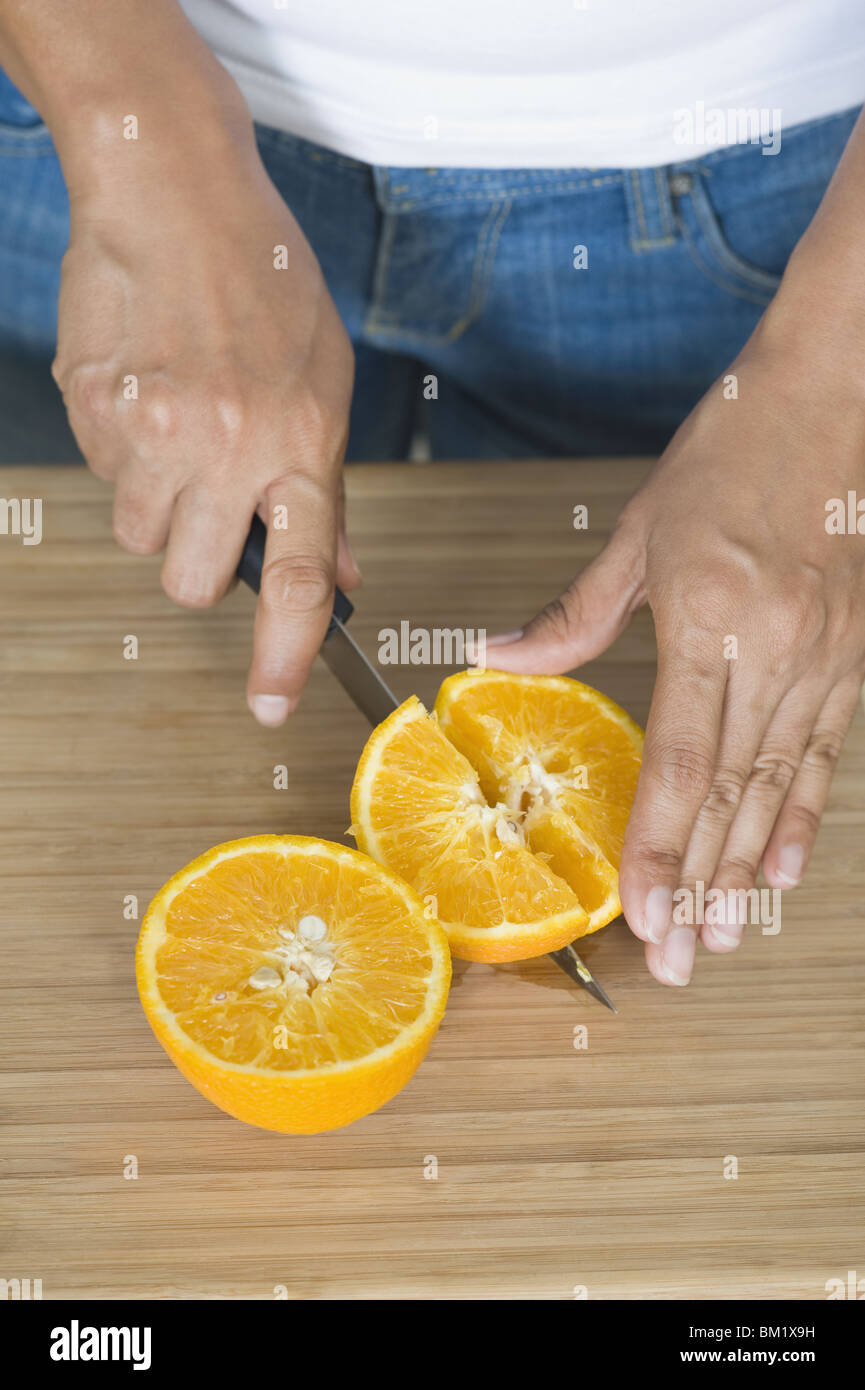 Mid section view of a woman cutting an orange Stock Photo - Alamy