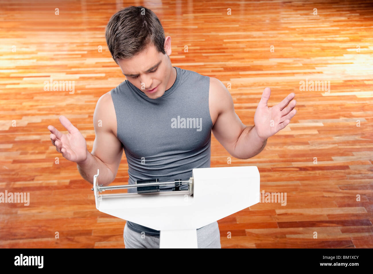 Man measuring his weight on a weighing scale Stock Photo - Alamy