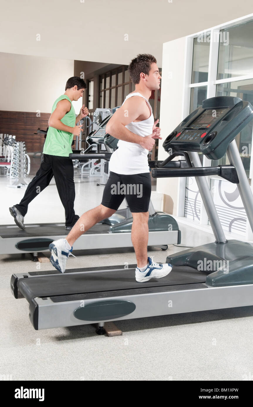 Two men running on treadmills Stock Photo - Alamy