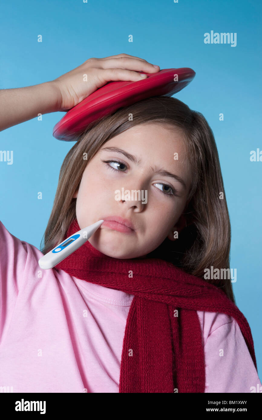 Girl taking her temperature and applying ice pack Stock Photo - Alamy