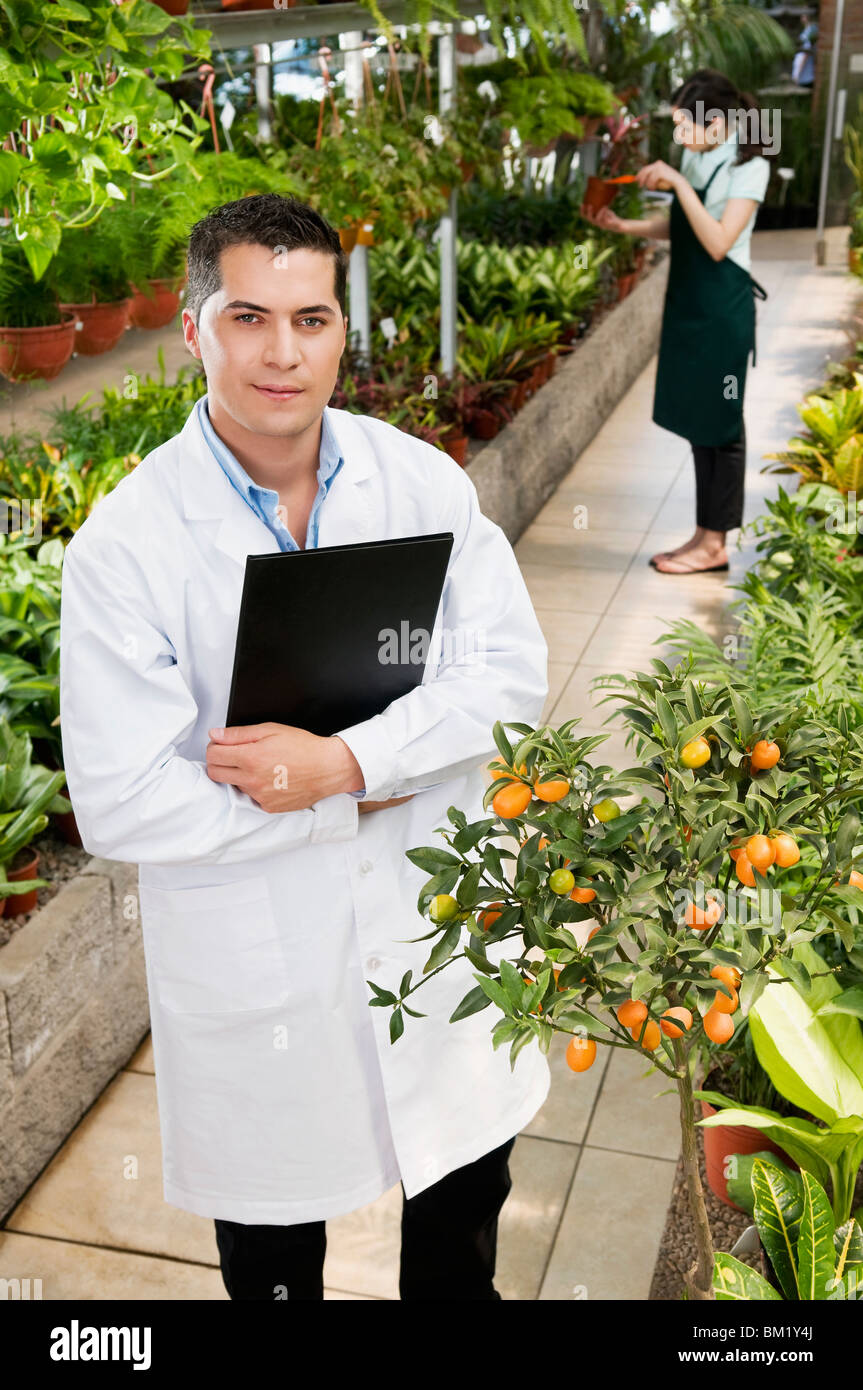 Scientist holding a clipboard in a greenhouse Stock Photo - Alamy