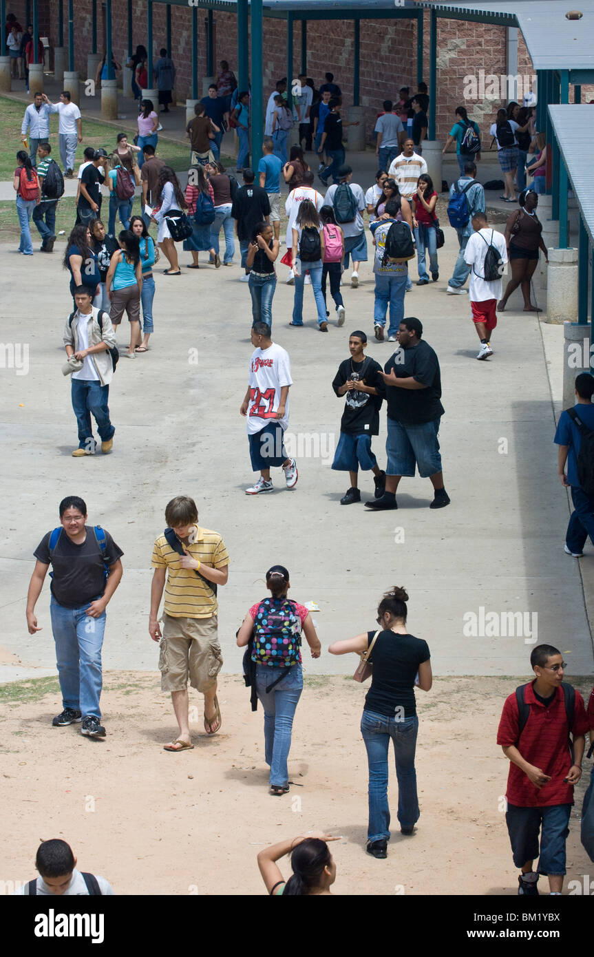 Multi-ethnic crowd of high school students walk through courtyard on ...