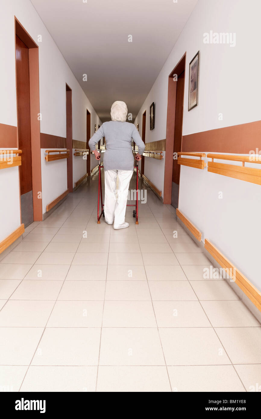 Rear view of a woman walking with the help of walker Stock Photo - Alamy