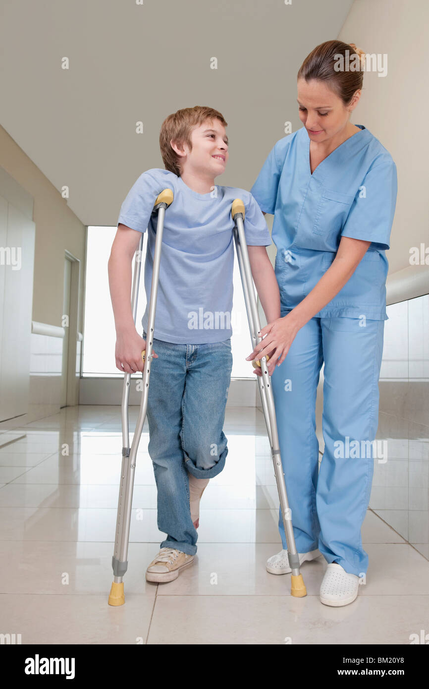 Doctor assisting a patient to walk Stock Photo - Alamy