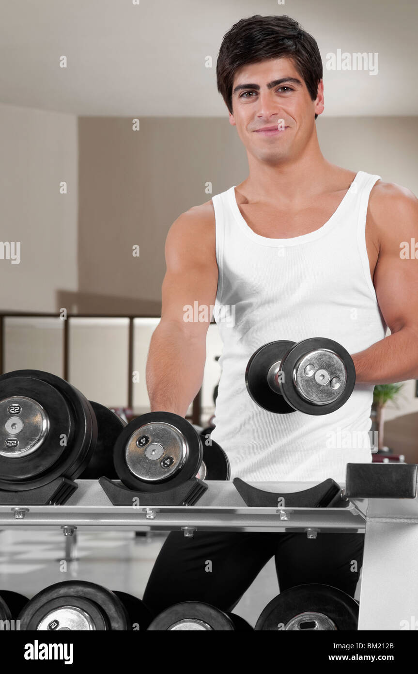 Man picking up a dumbbell in a gym Stock Photo - Alamy