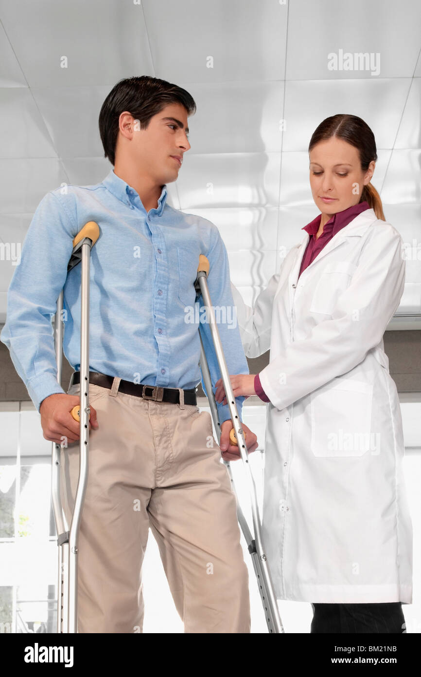 Doctor assisting a patient to walk Stock Photo - Alamy