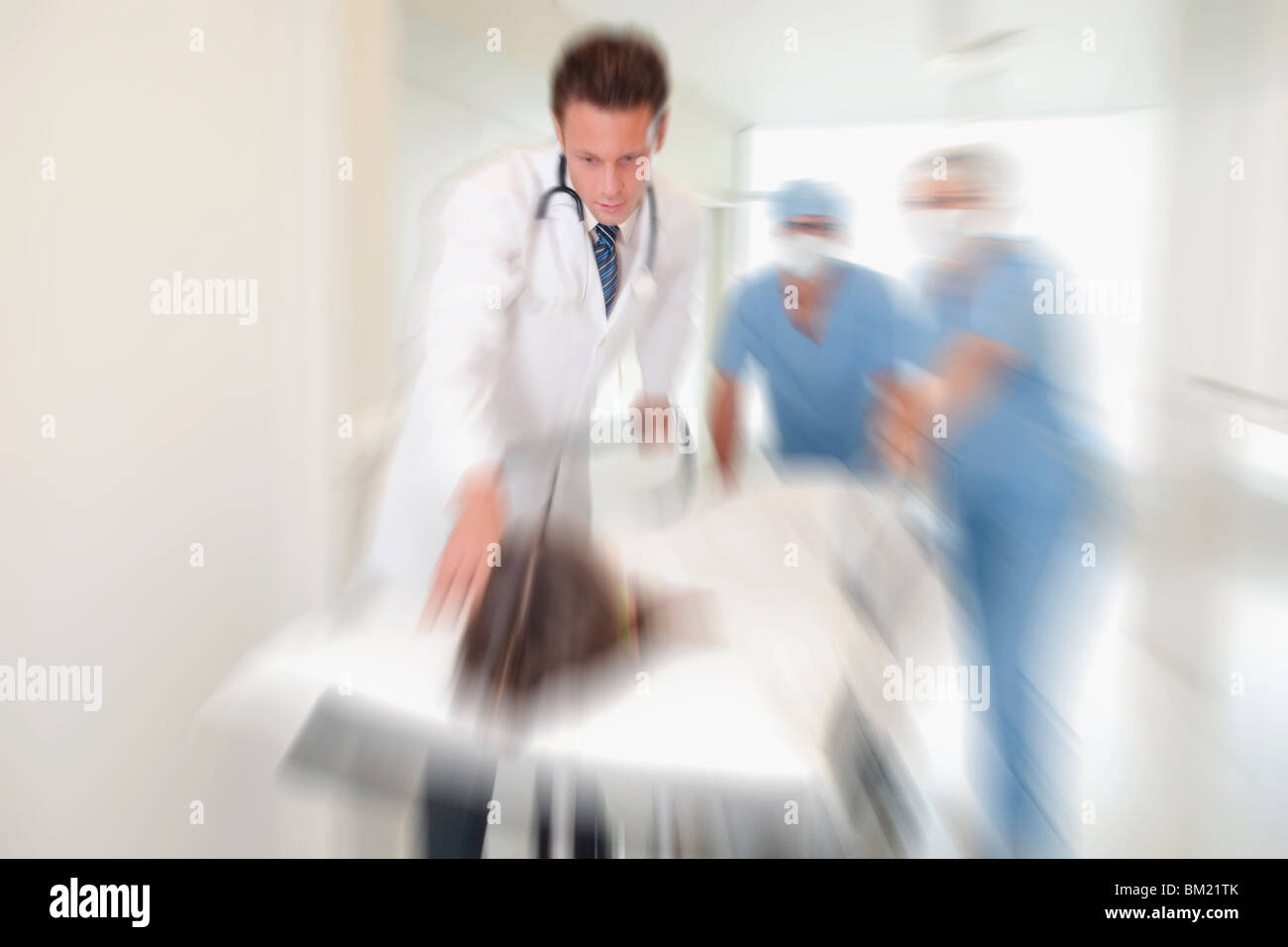 Doctors pushing a patient on a hospital Gurney in a hospital corridor ...