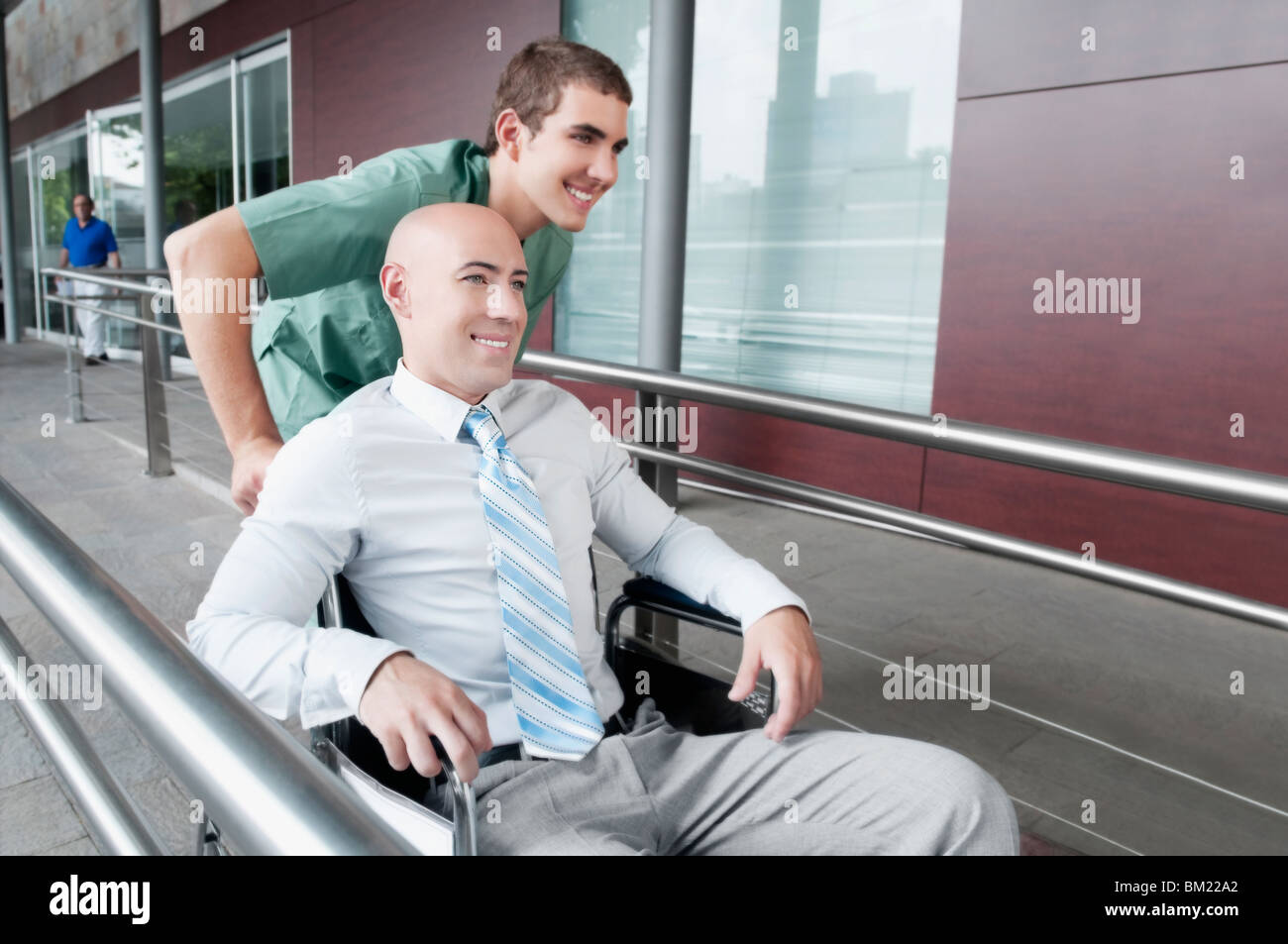 Male nurse pushing a man in wheelchair Stock Photo - Alamy