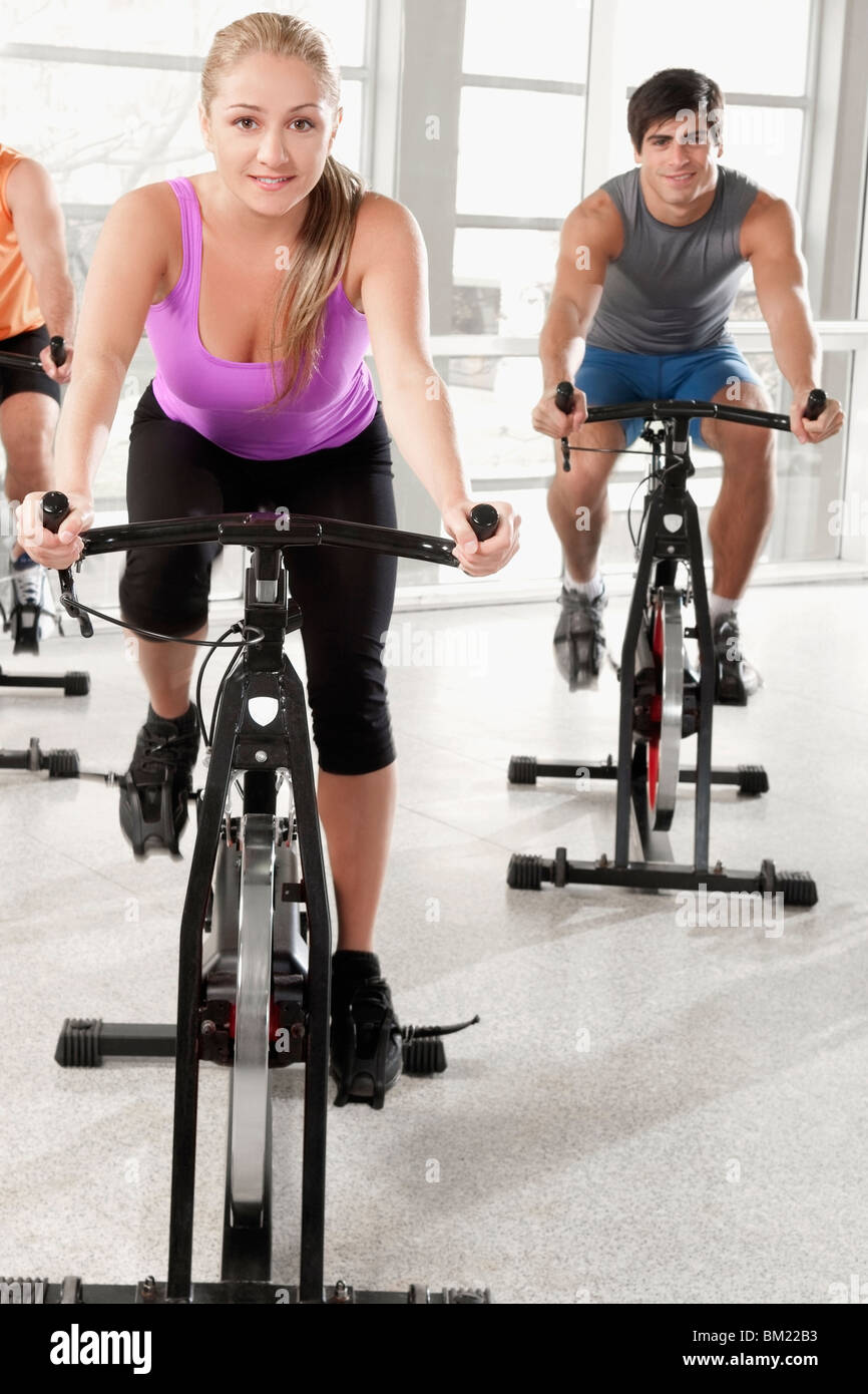 Three people working out on exercise bikes in a gym Stock Photo - Alamy