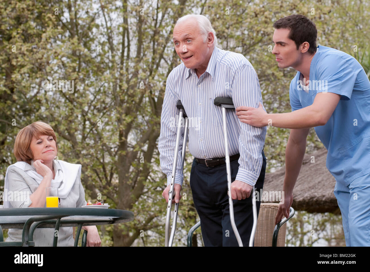 Health worker assisting a disabled man Stock Photo - Alamy