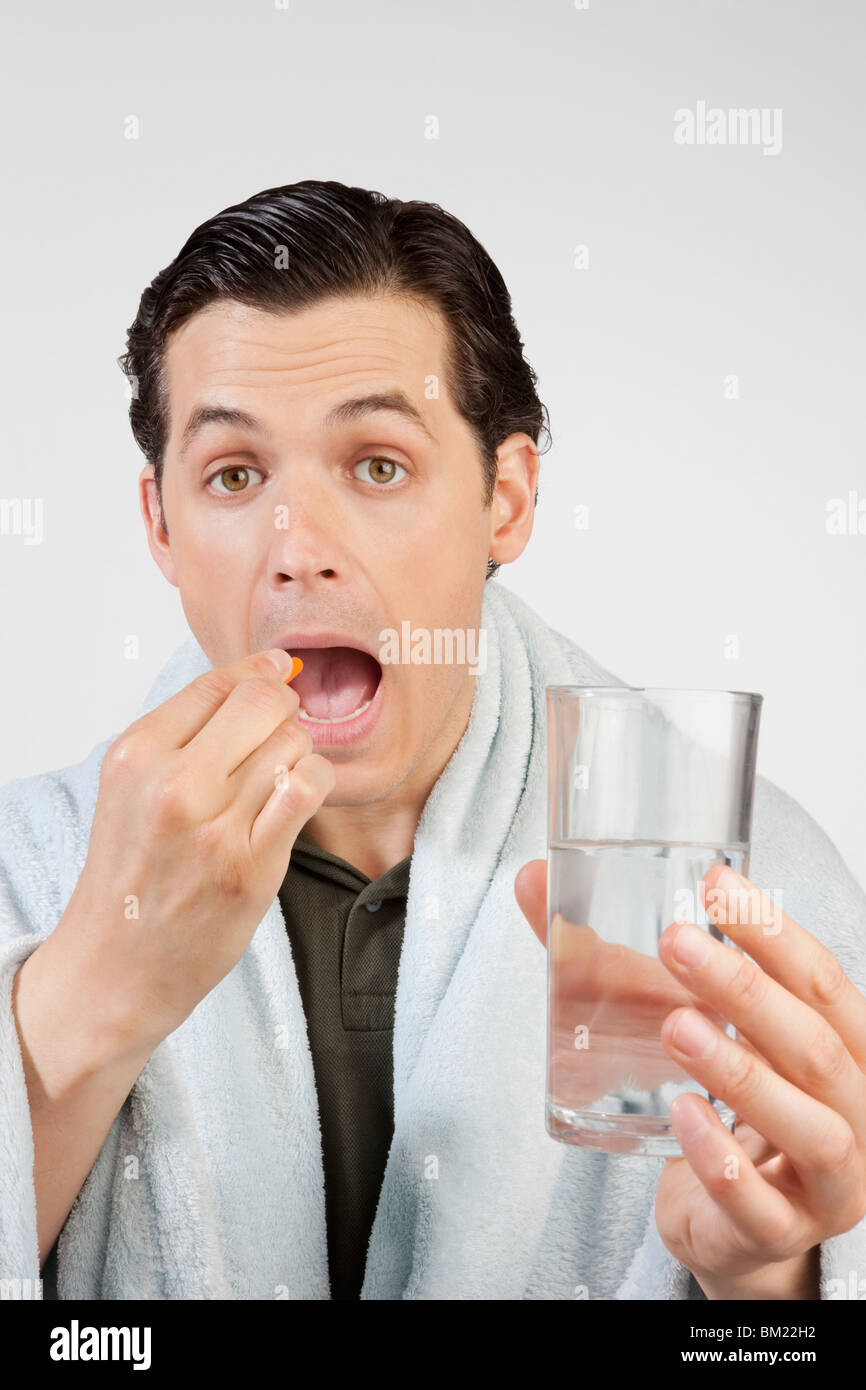 Portrait of a man taking medicine Stock Photo - Alamy