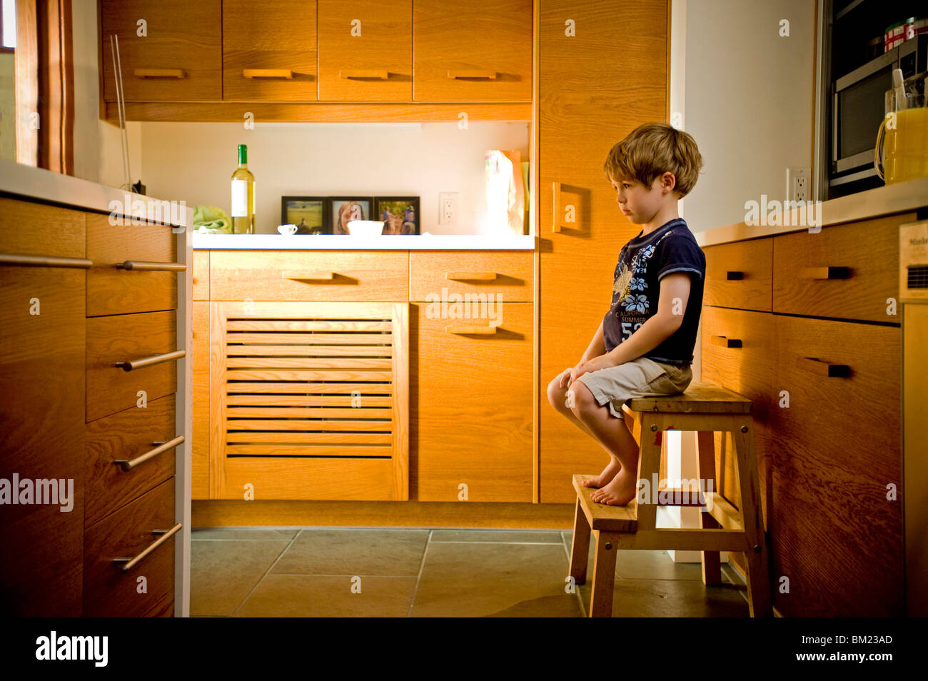 Boy sitting on a stool in the kitchen, La Jolla, California, USA Stock ...