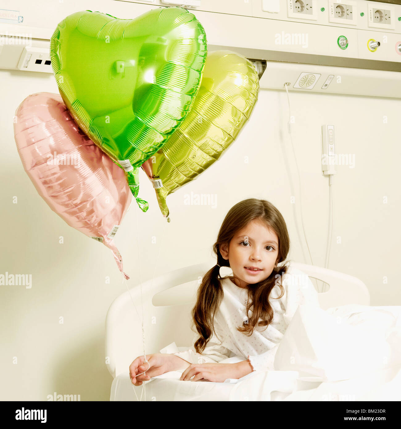 Girl with balloons on a hospital bed Stock Photo - Alamy