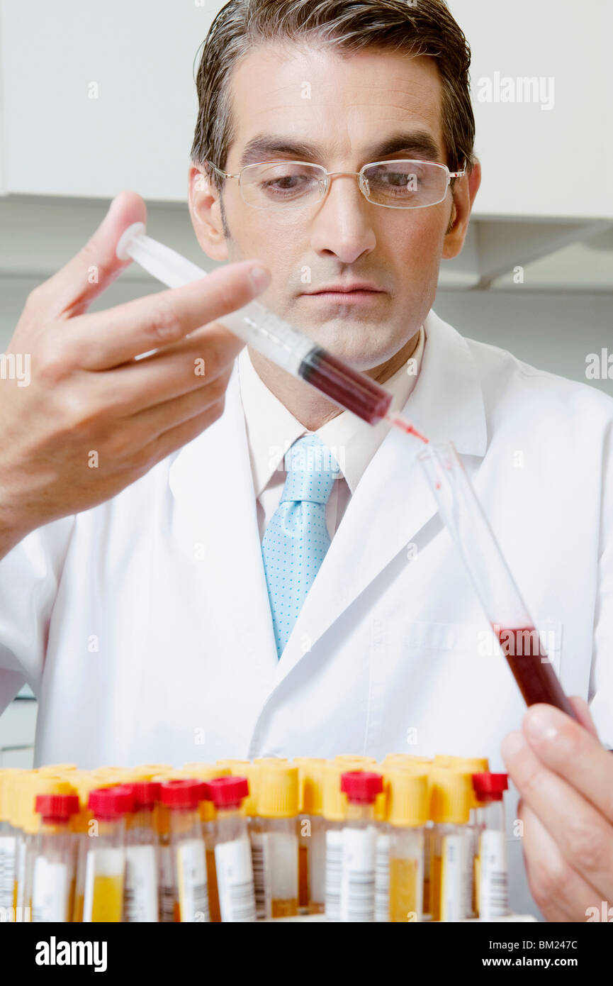 Lab technician filling blood in a test tube from a syringe Stock Photo ...