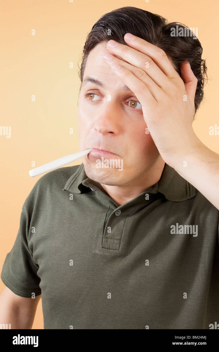 Man checking his temperature with a thermometer Stock Photo - Alamy
