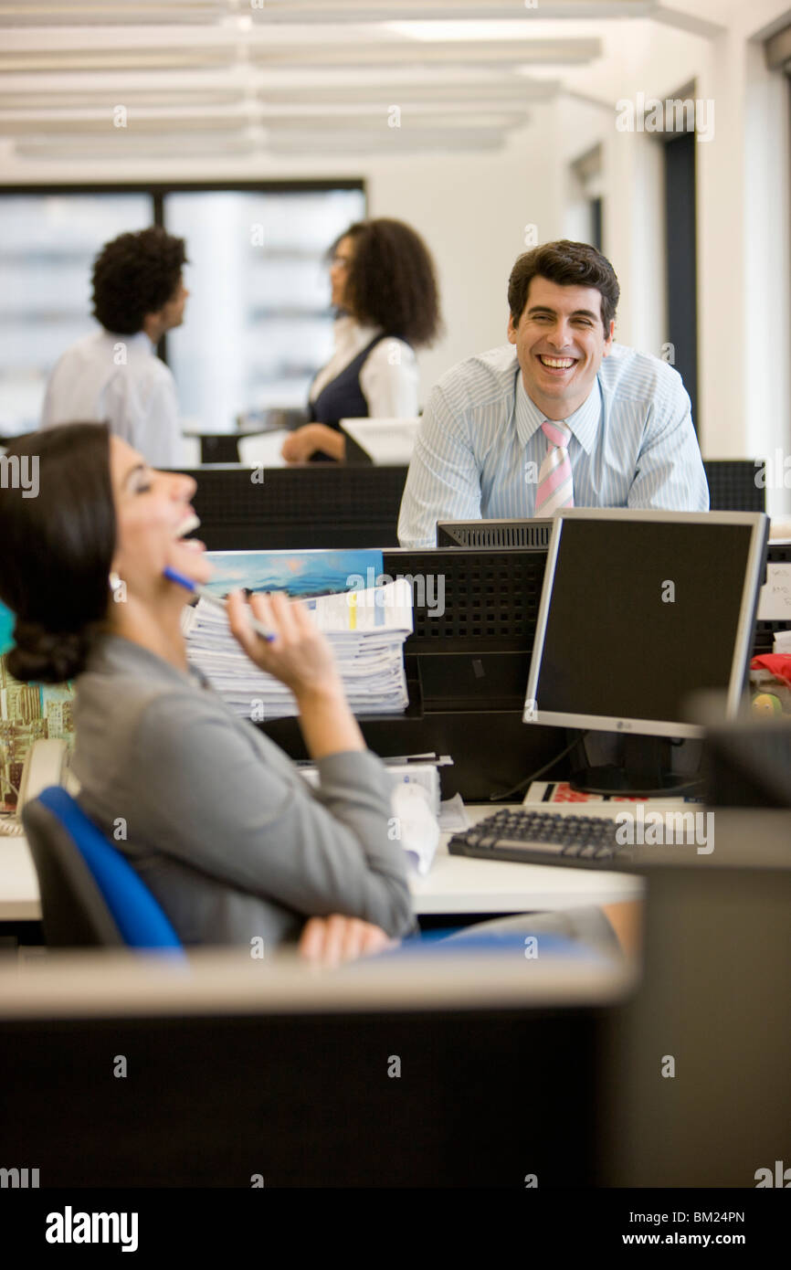 Office workers chatting while working in office Stock Photo - Alamy