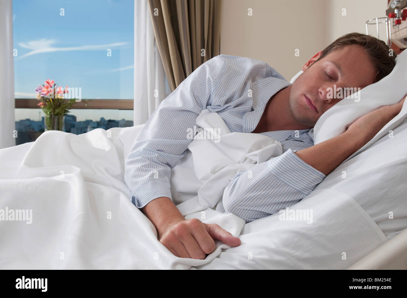 Man lying in a hospital bed Stock Photo - Alamy