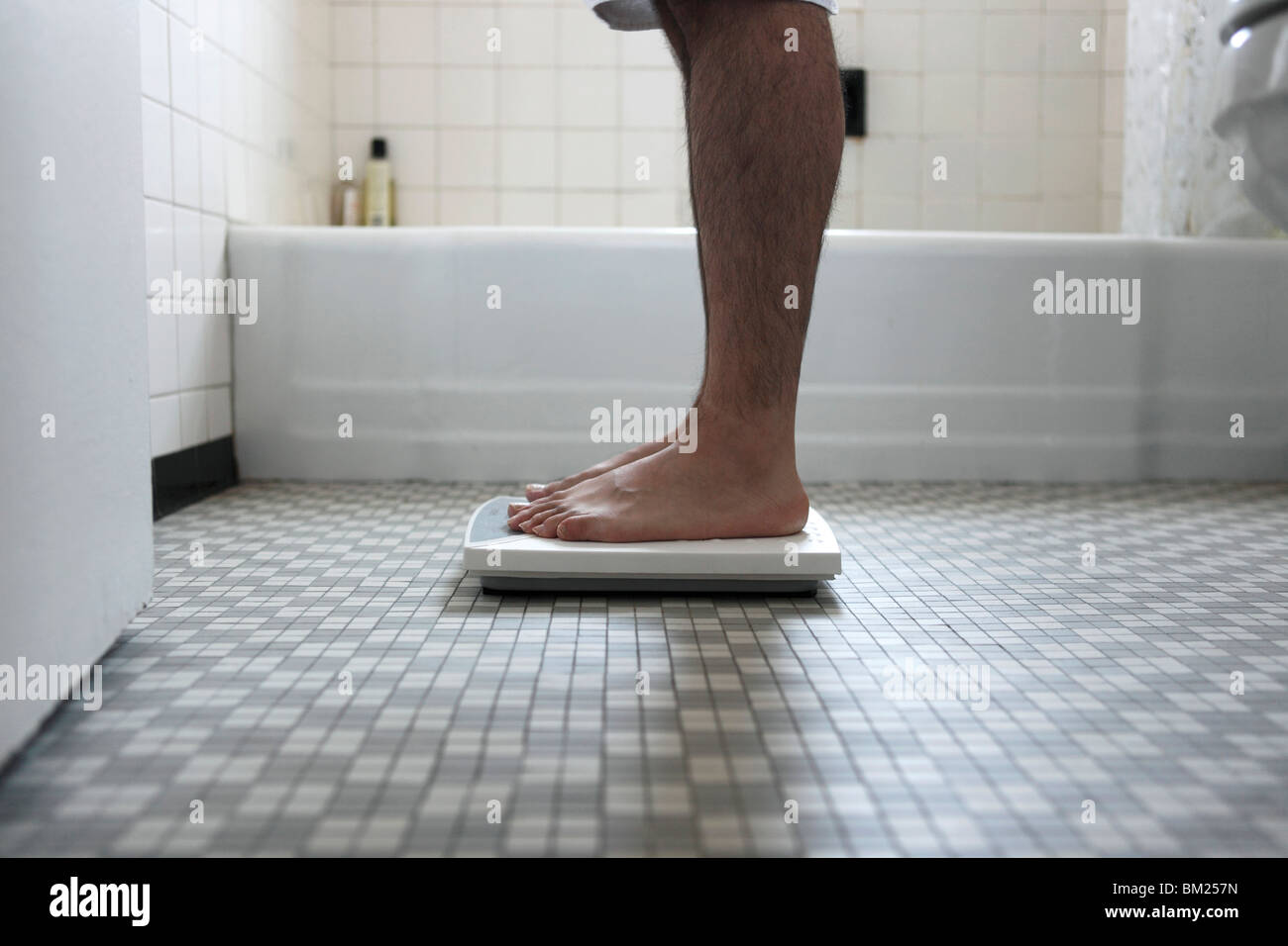 Low section view of a man standing on a scale Stock Photo - Alamy