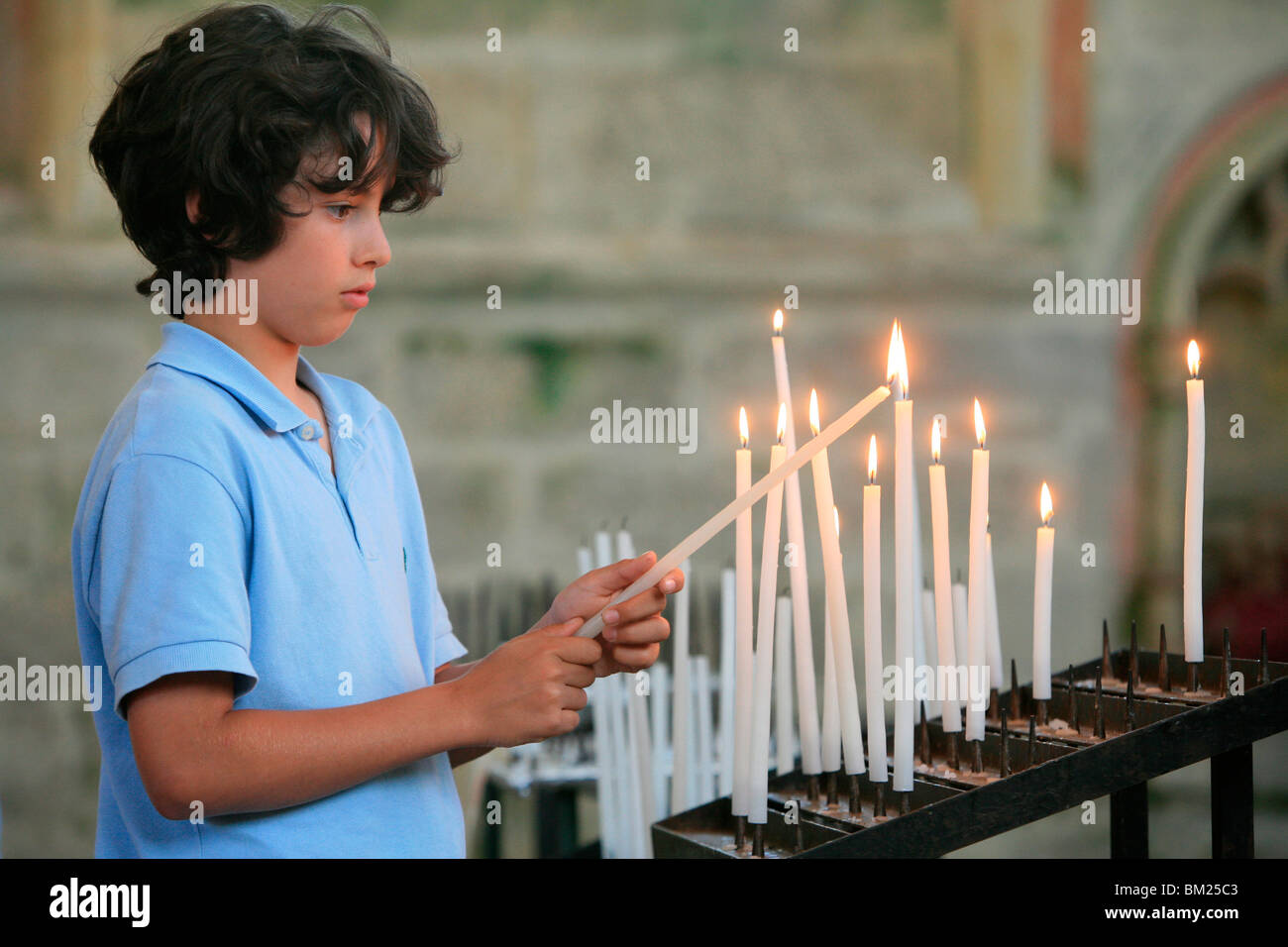 Boy lighting a church candle Stock Photo - Alamy