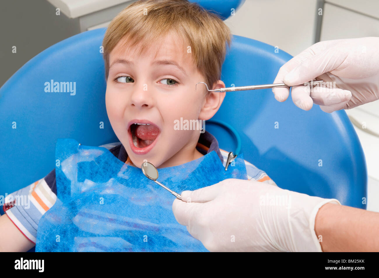 Dentist examining a boy's teeth Stock Photo - Alamy