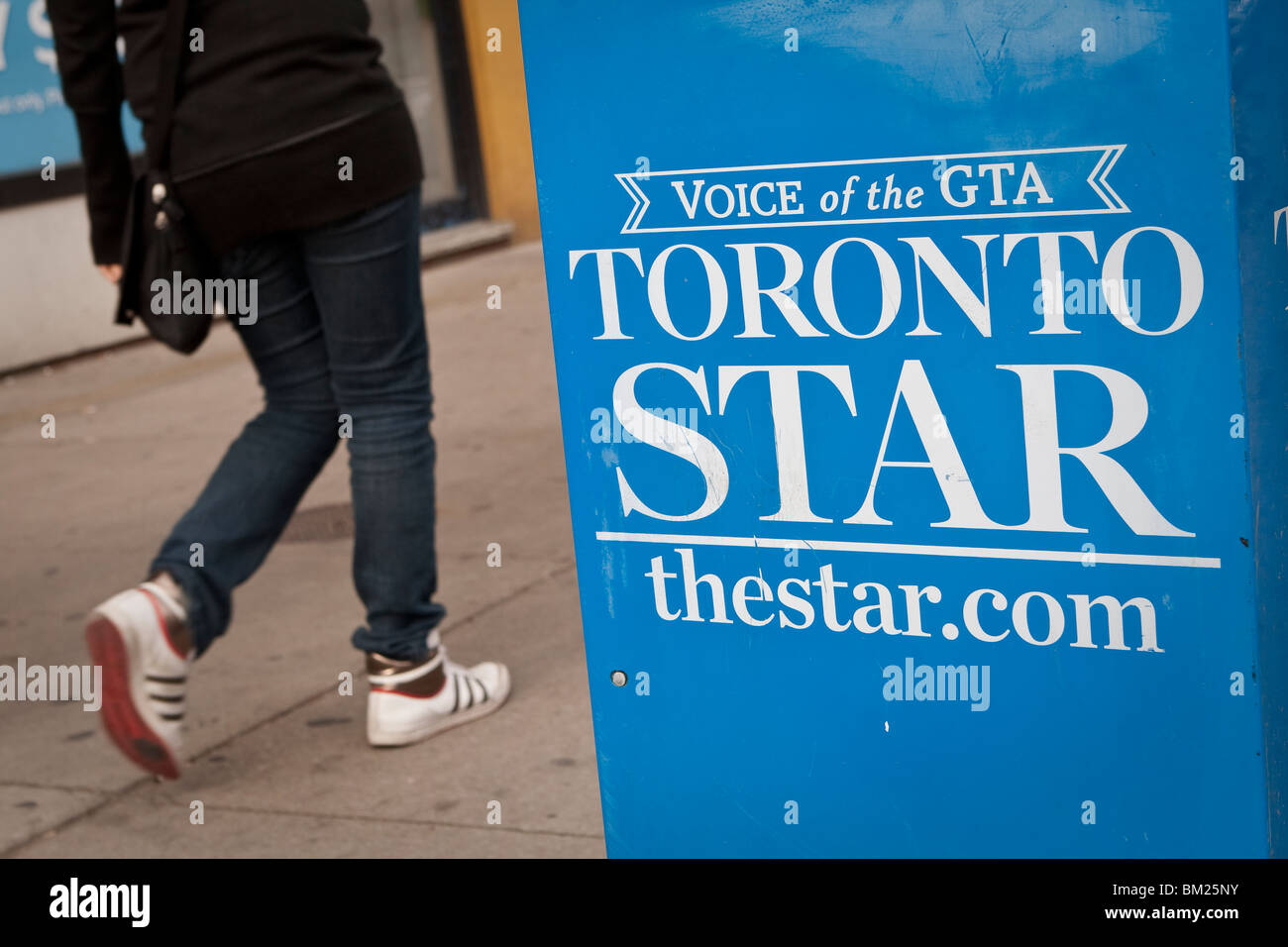A woman walks by a Toronto Star newspaper box in Toronto Stock Photo ...